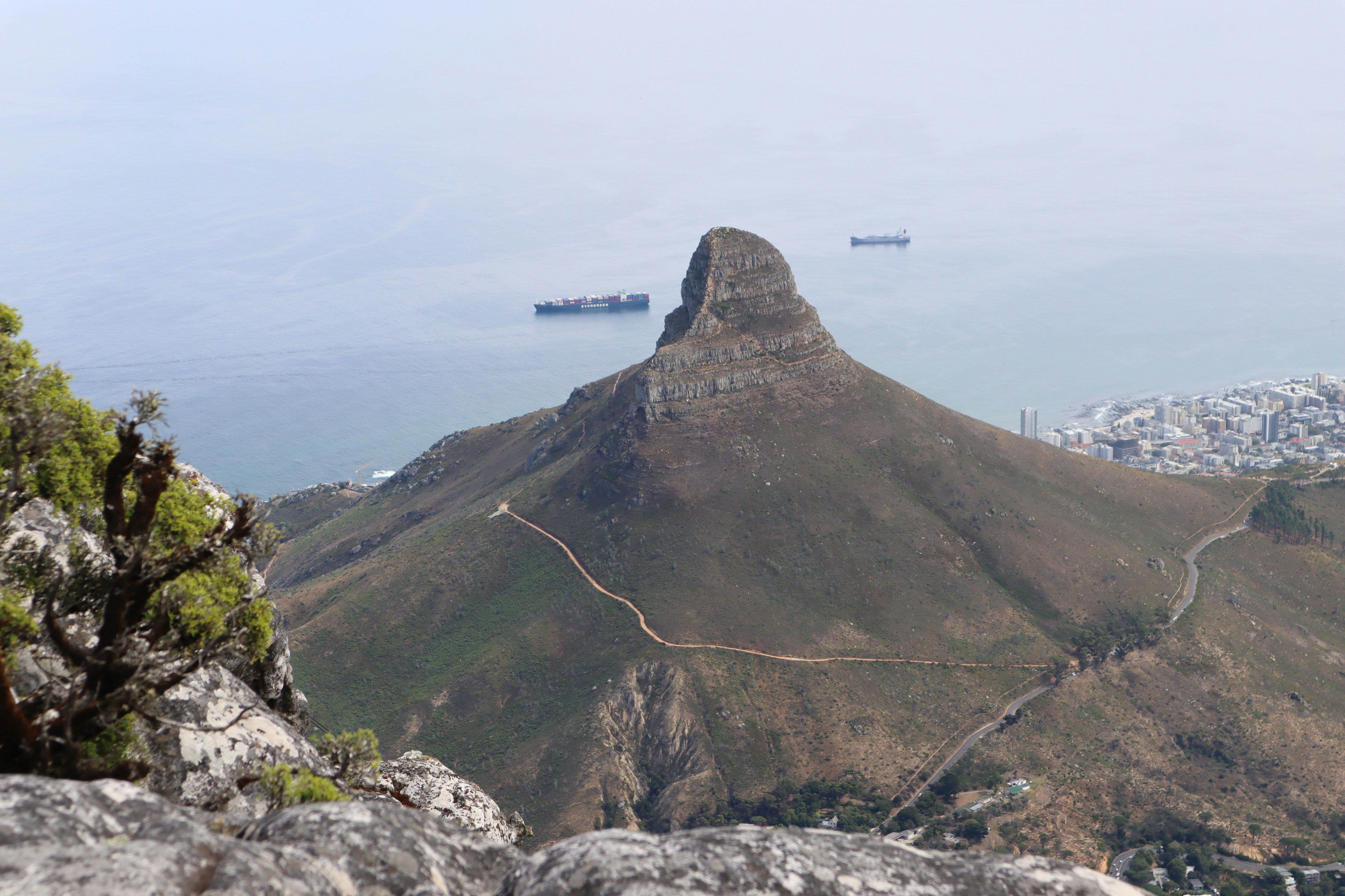Lone Pinnacle Over the Coastal Ridge, Boats on a Quiet Horizon