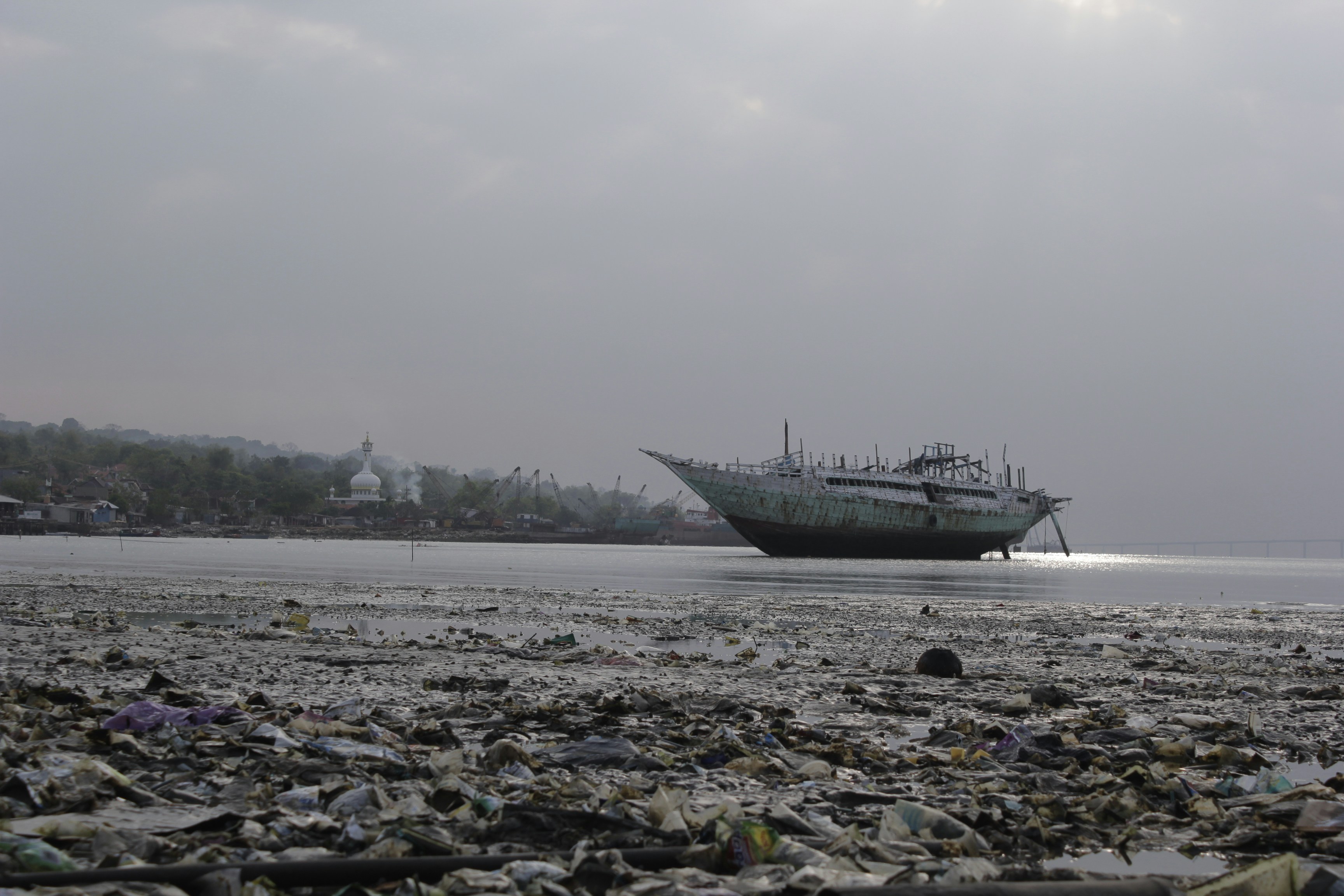 Cargo Ship on a Quiet Horizon over Pebble-Studded Shore