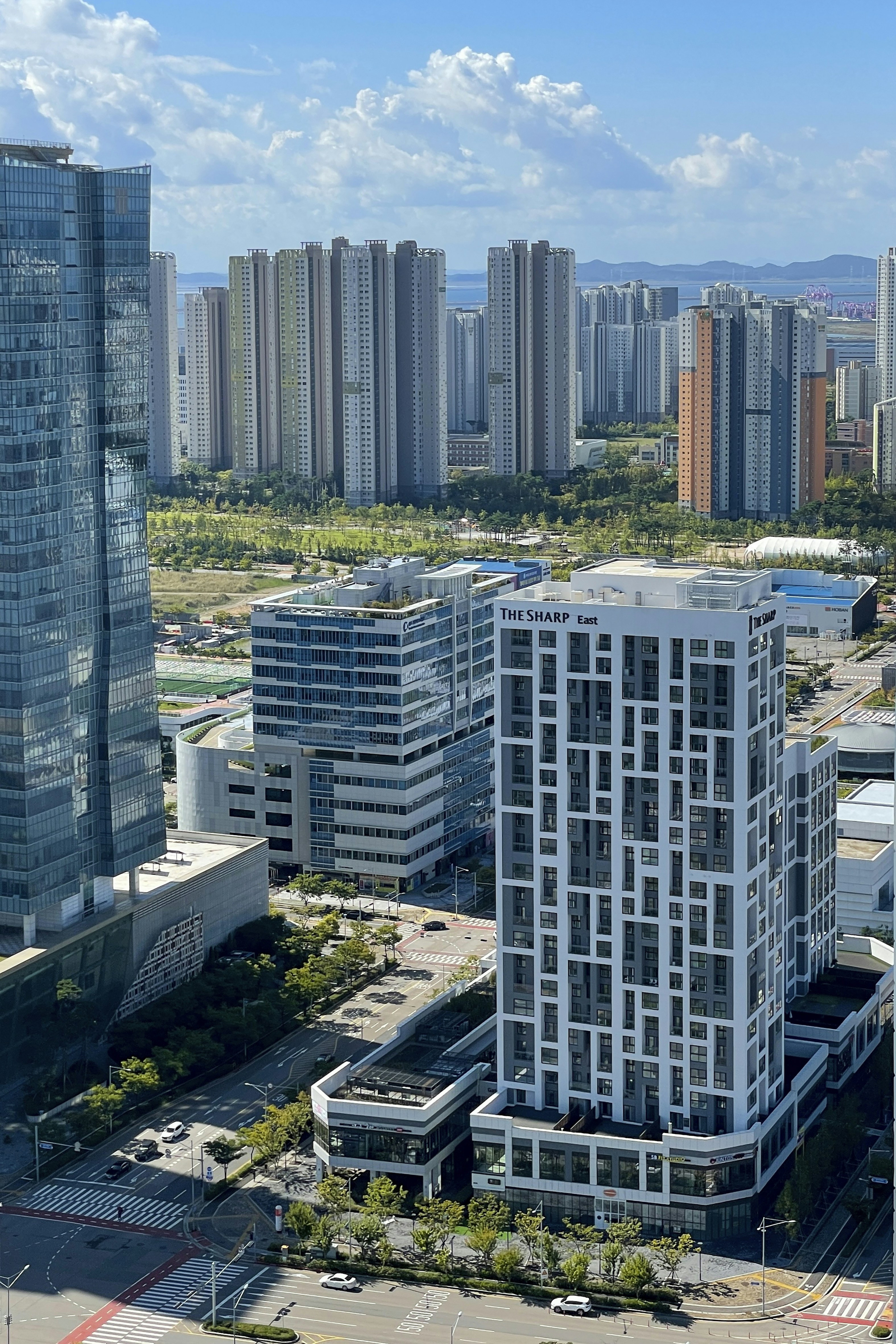 High-rise buildings and a modern structure dominate the urban skyline, showcasing contemporary architecture amidst a vibrant cityscape.