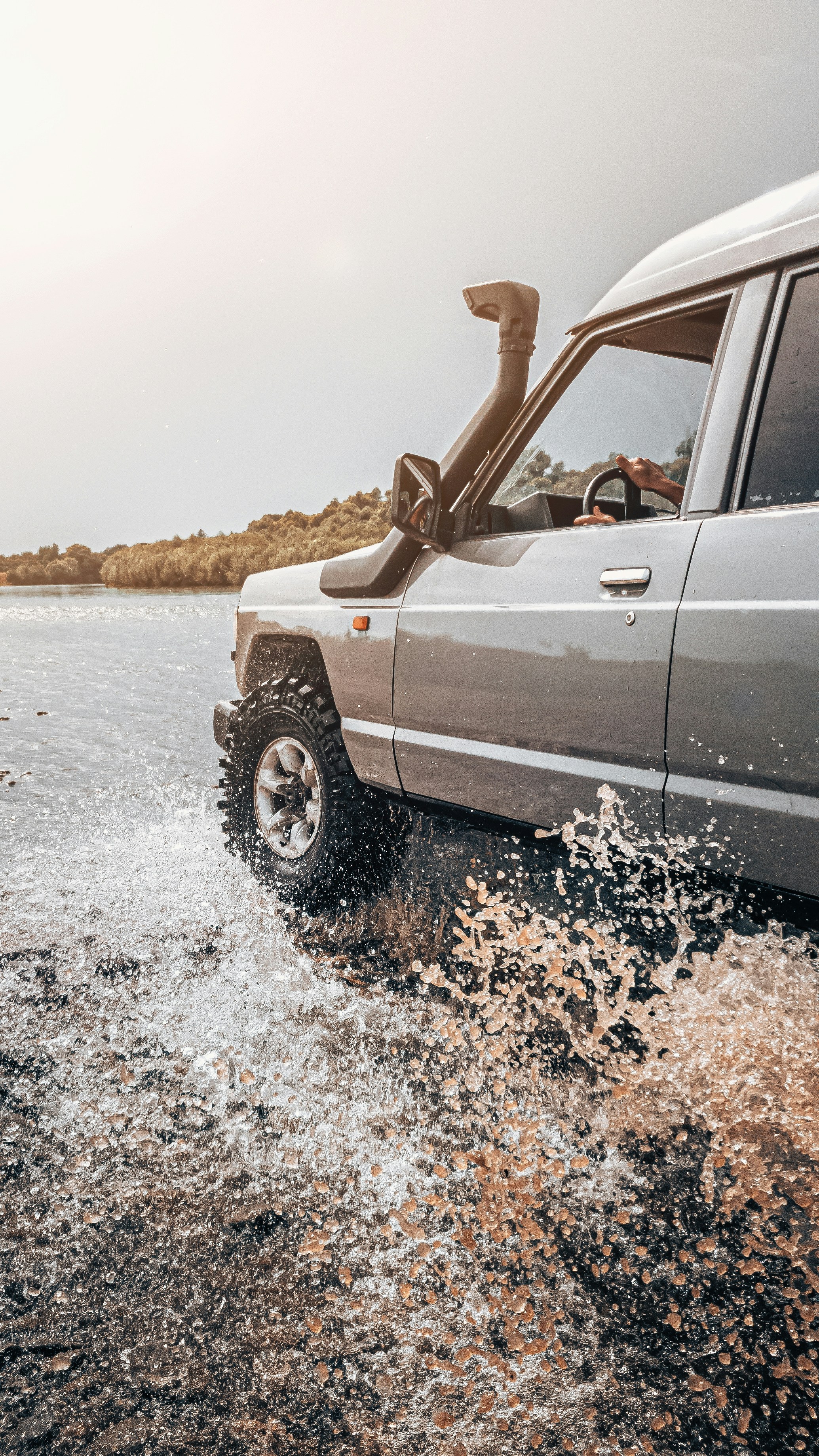Silver SUV Surges Through Shallow Surf: Off-Road Splash Moment