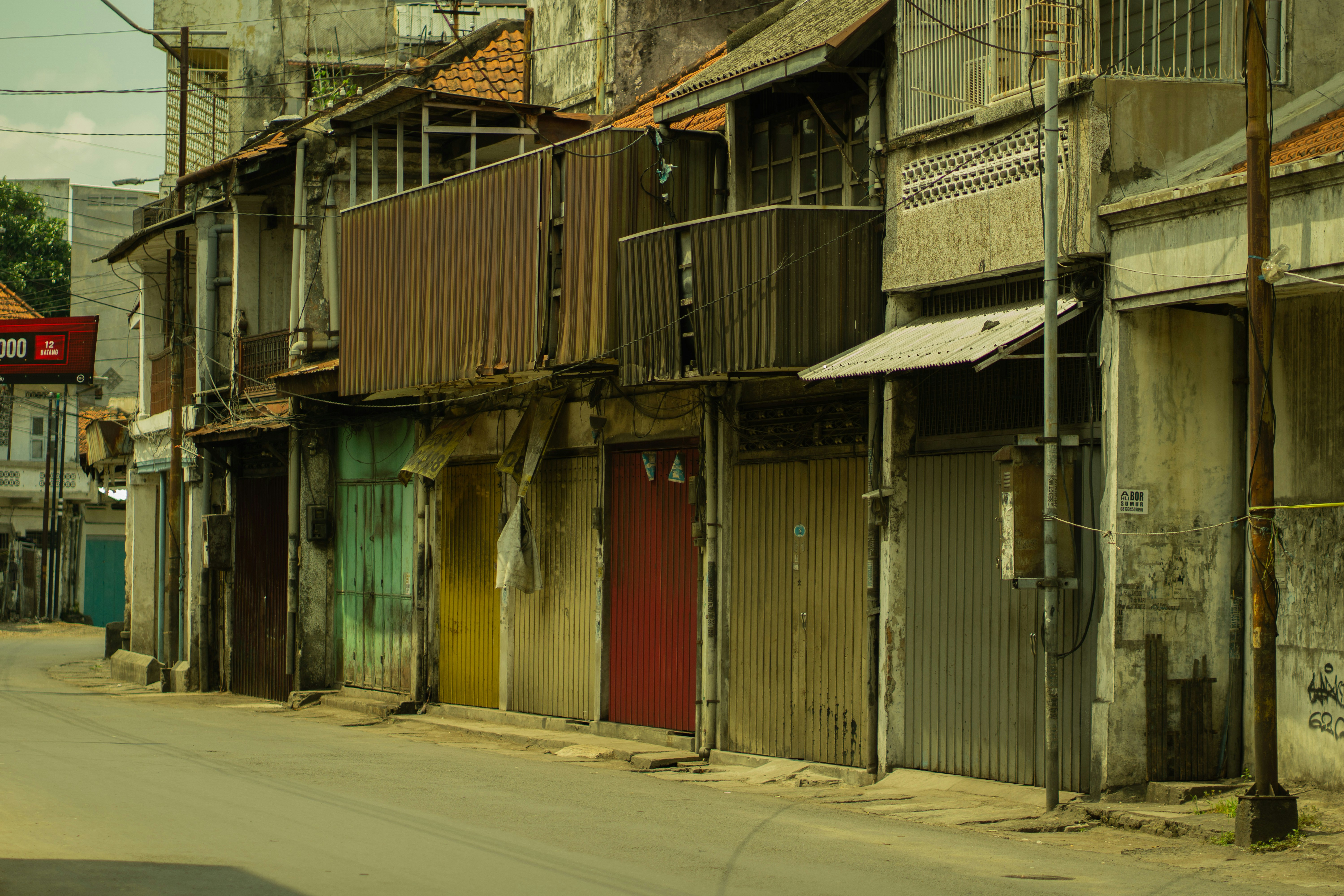 Sun-bleached Doors: A Row of Weathered Storefronts Along a Quiet Street