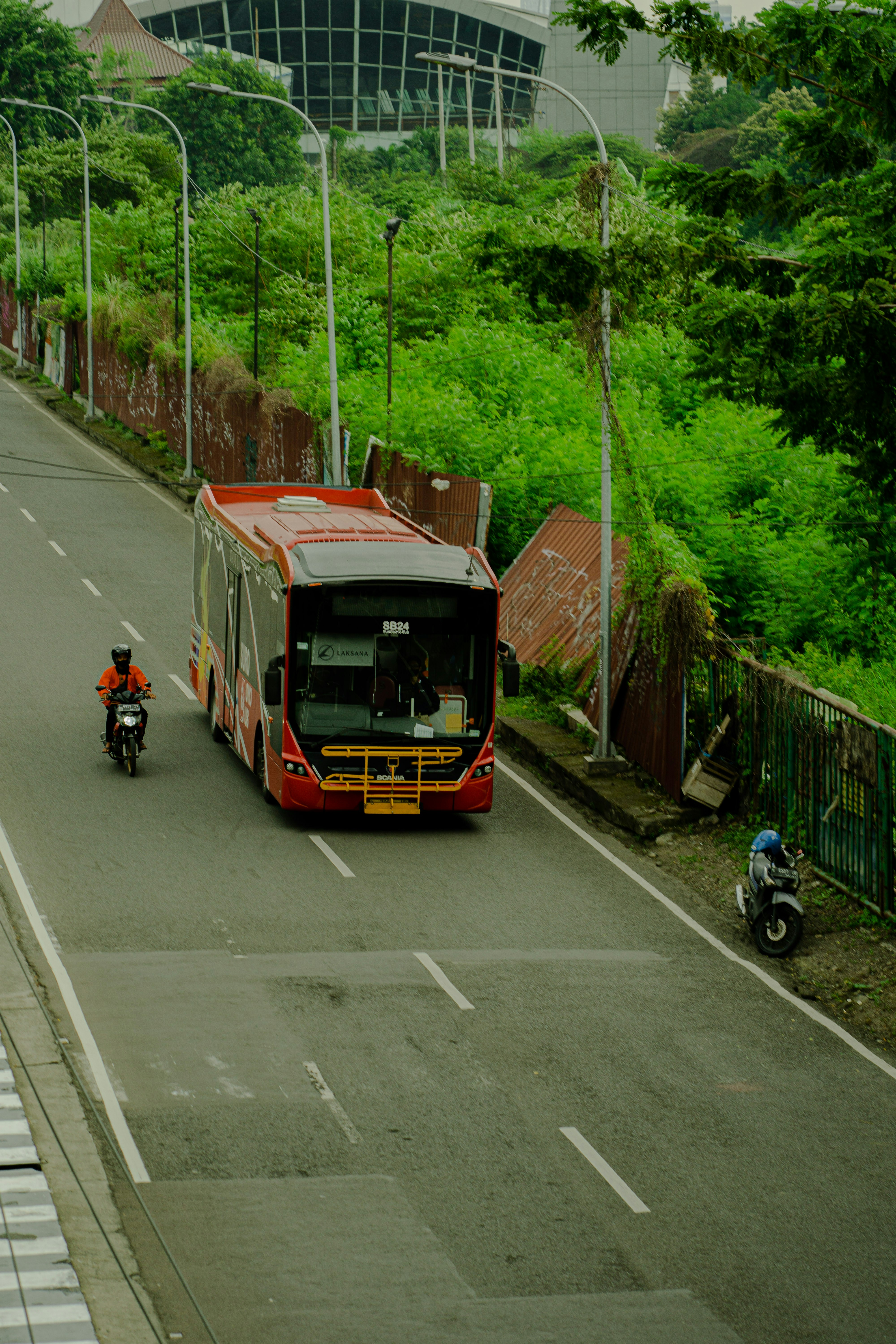 Un bus rouge roulant dans une rue à côté d’une moto photo – Photo ...