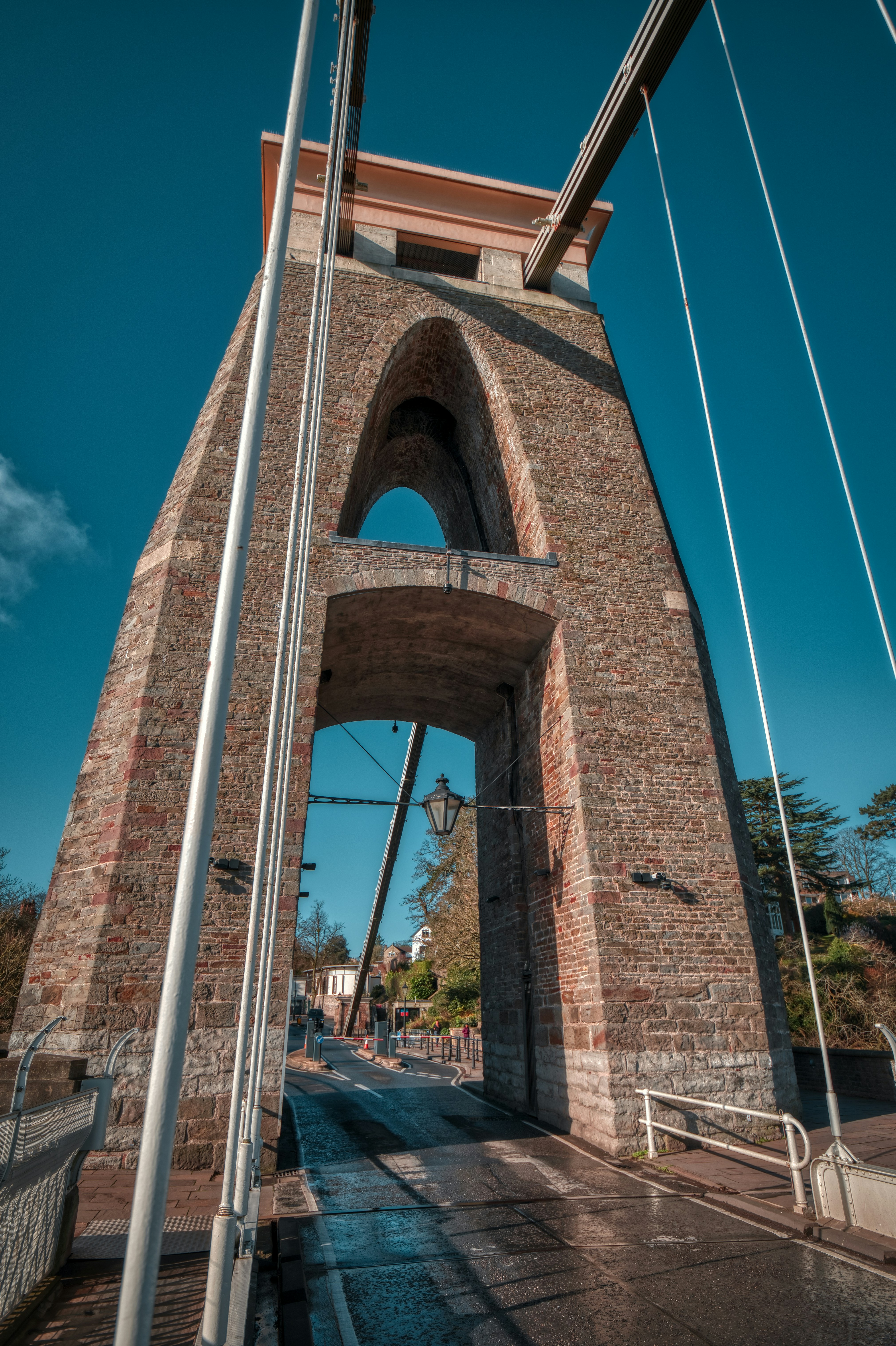 Bridge Archway Rising Through a Brick Tower Under a Clear Sky