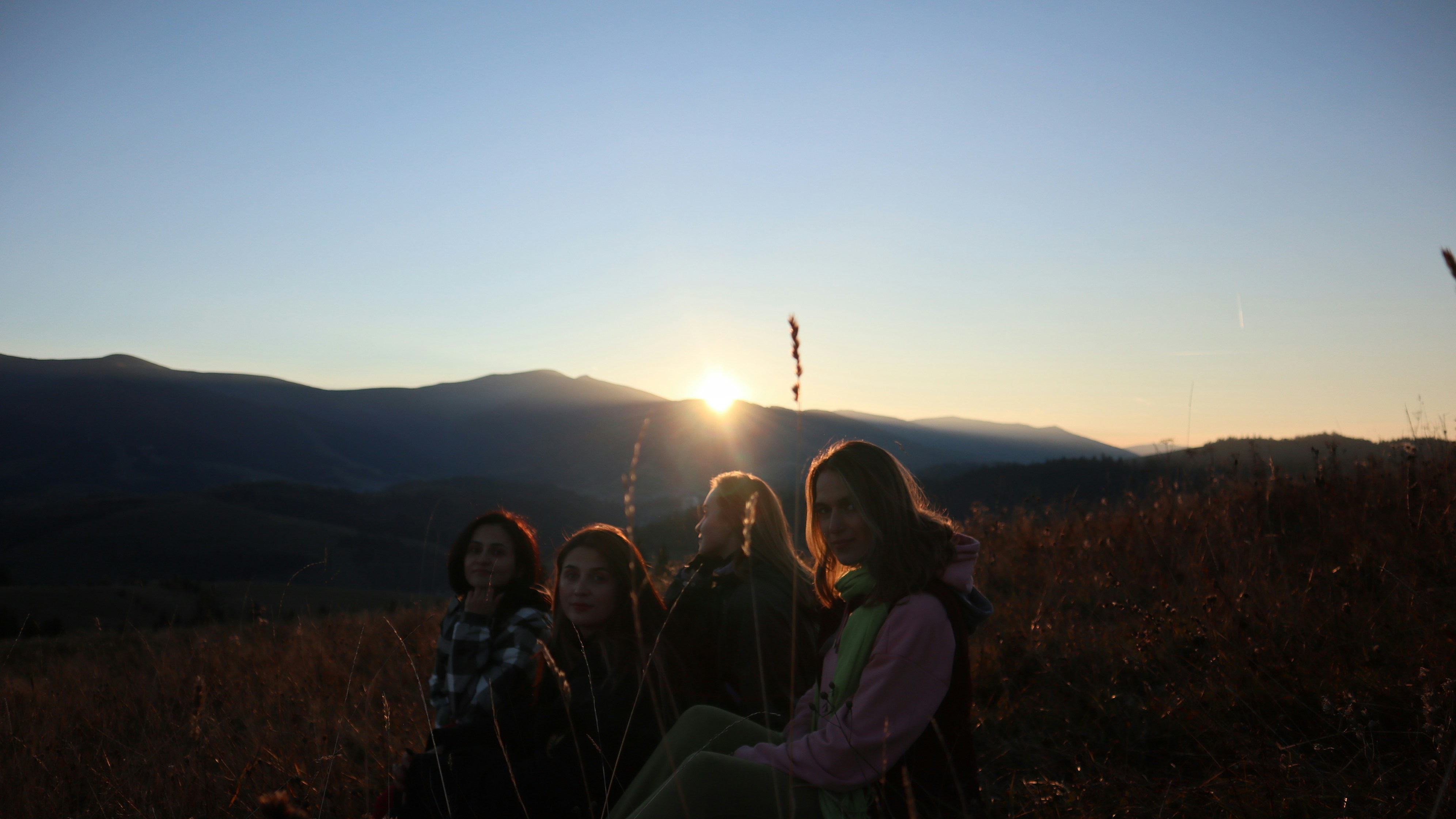 Dusk Ridge Portrait: Friends Silhouetted Against a Golden Horizon