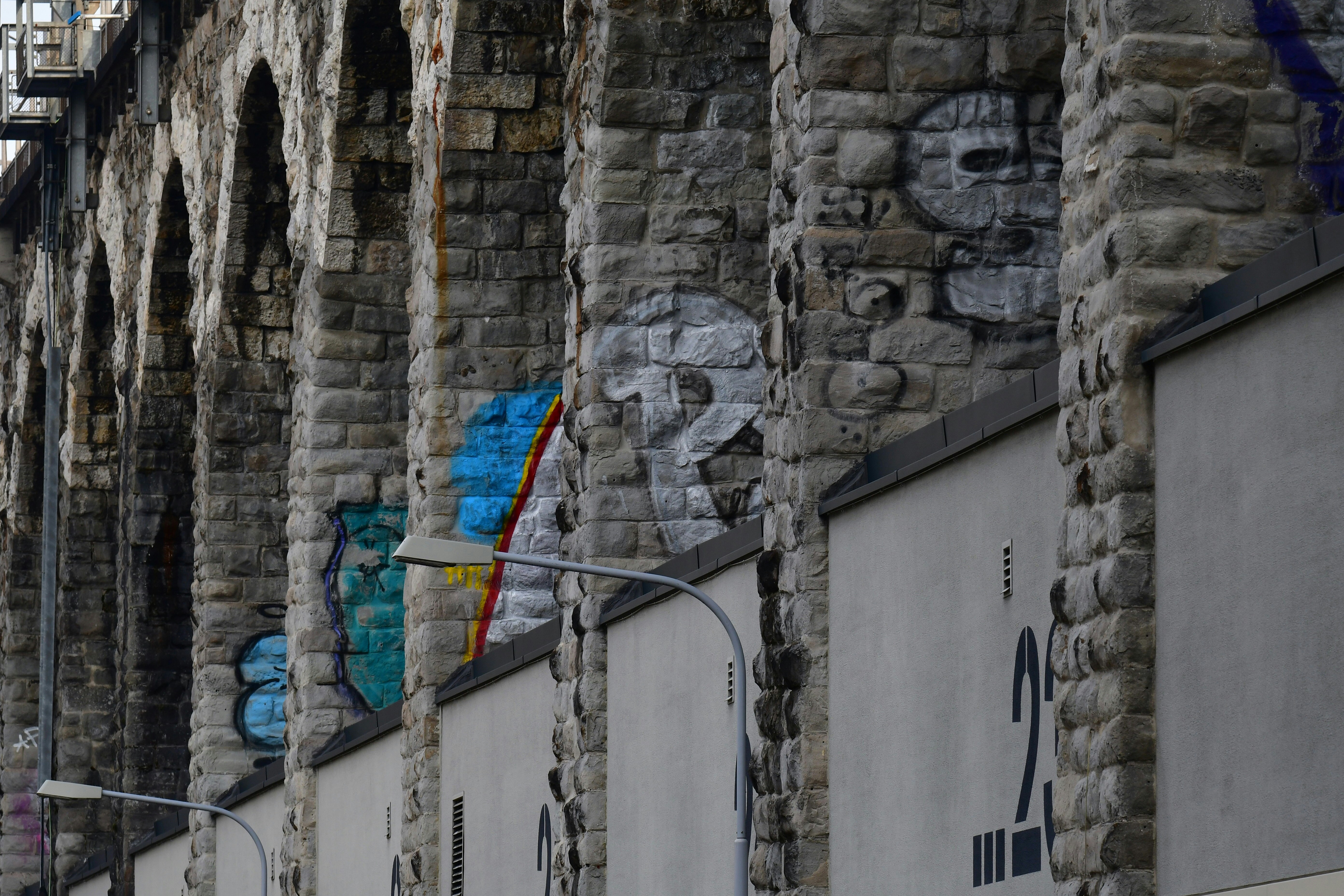 Between Stone Arches and Painted Panels: A Corridor of Graffiti and Light
