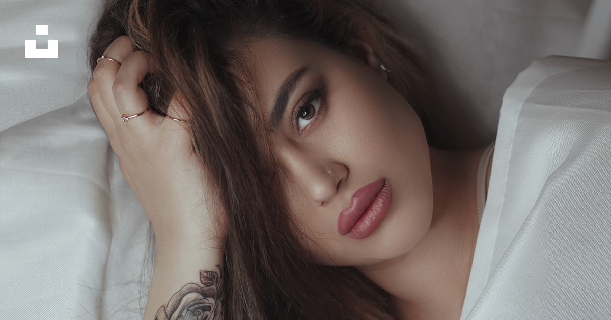 A Woman Laying In Bed With A Tattoo On Her Arm Photo Free Tehran