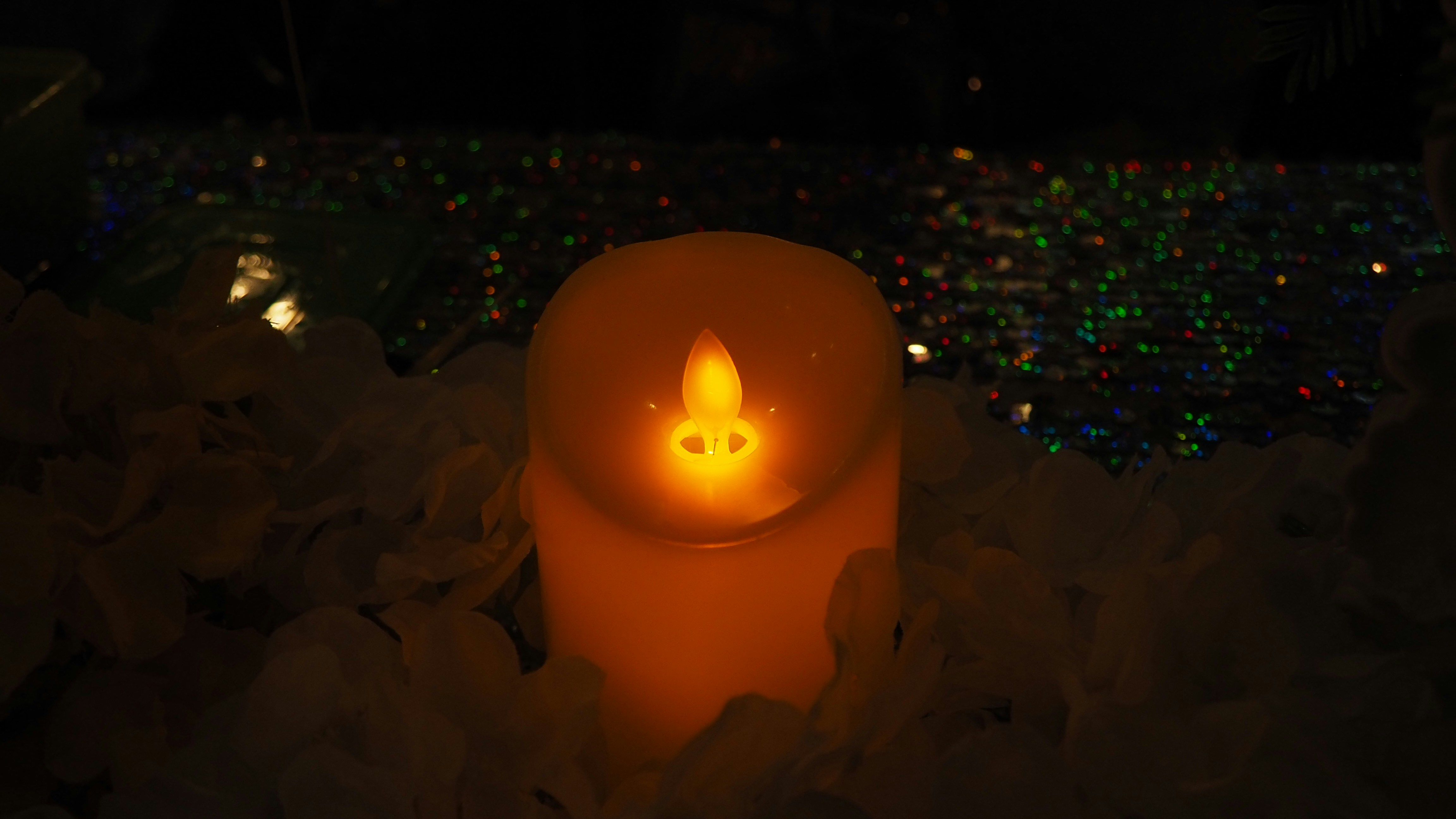 Amber Flame Amid Petal Mist in a Dim Room