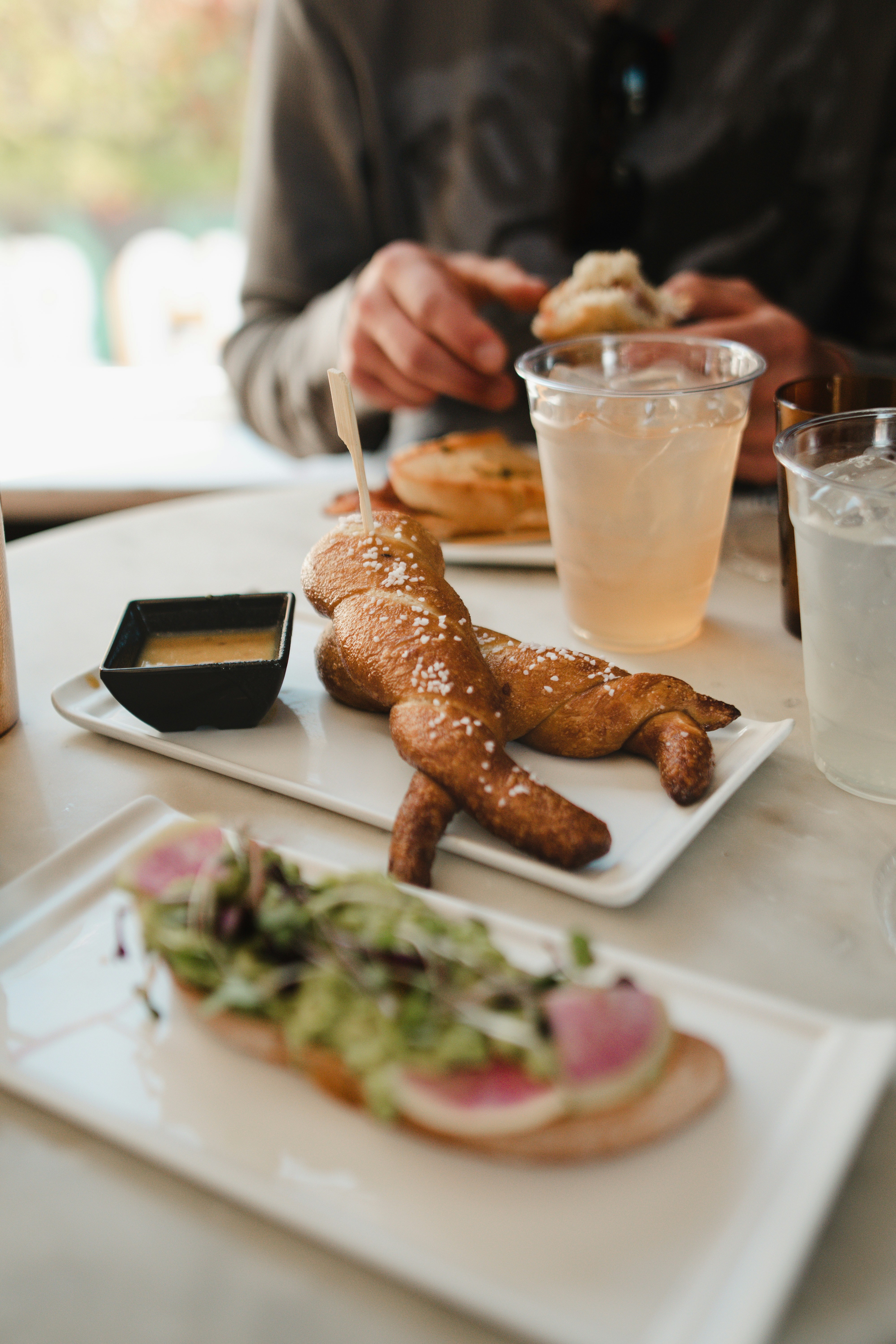 Sesame-Dusted Pretzel Sticks at a Sunlit Café Table