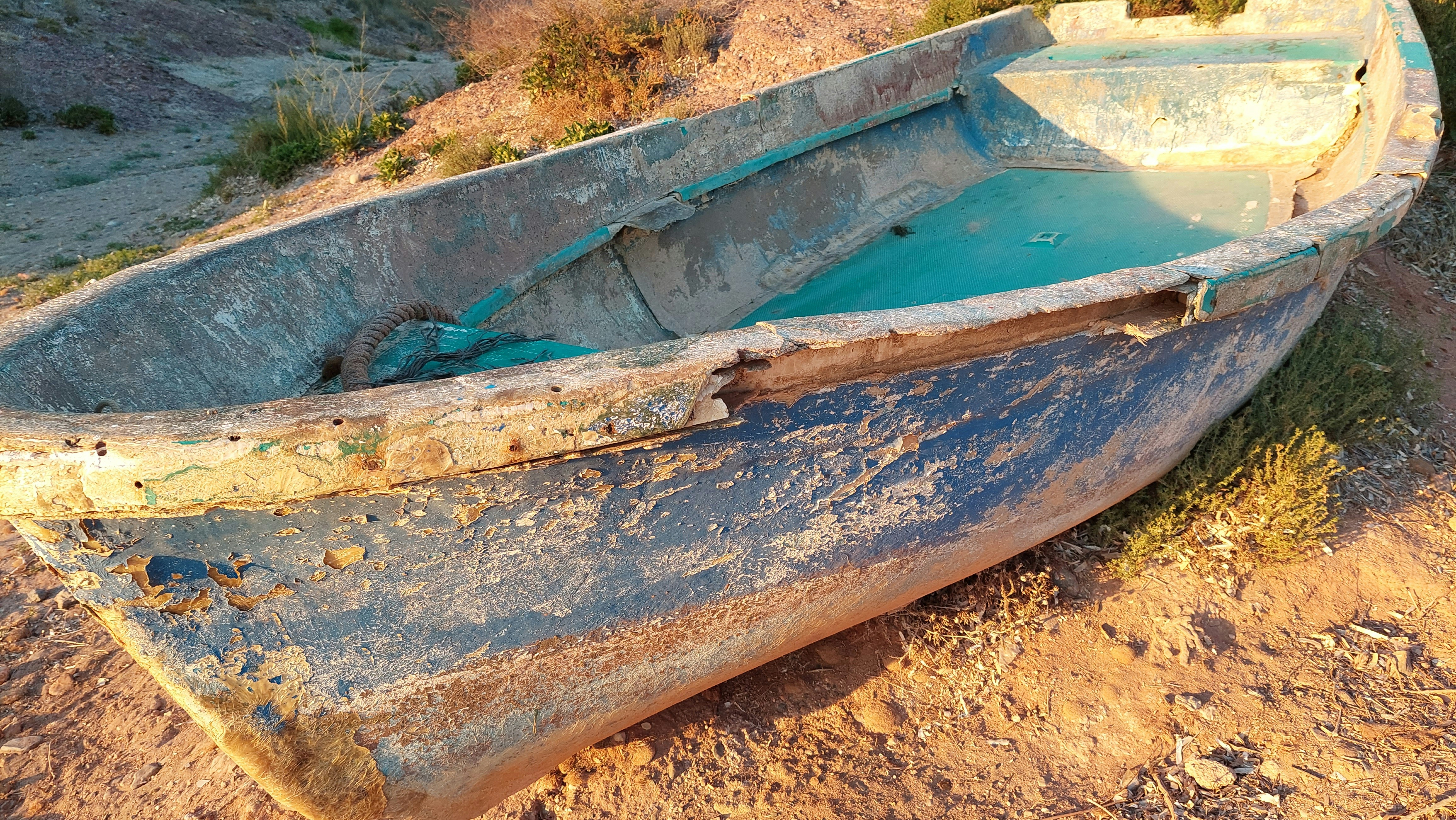 An old boat sitting on top of a dirt field photo – Free Boat Image on ...