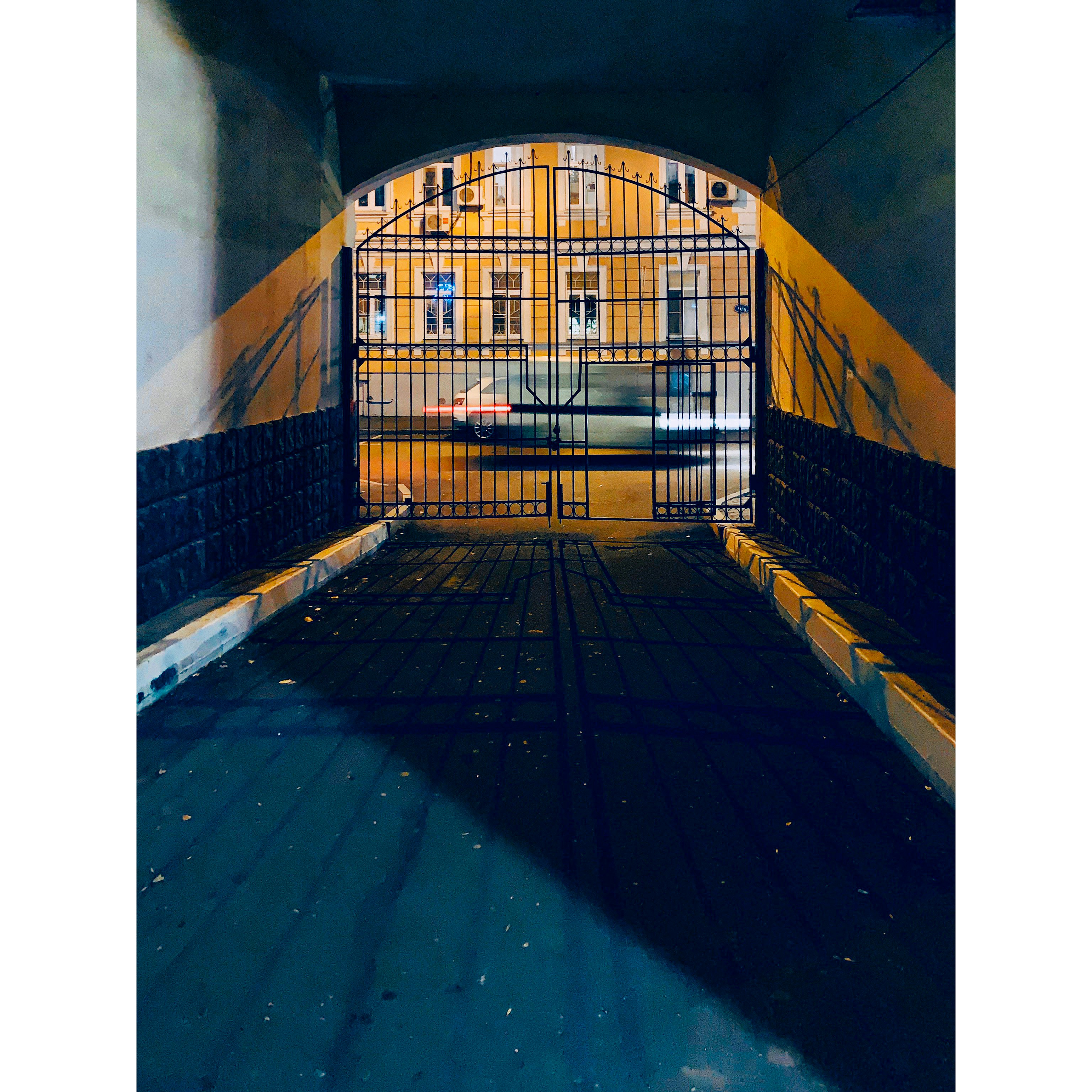 A car driving through a tunnel with a building in the background photo ...