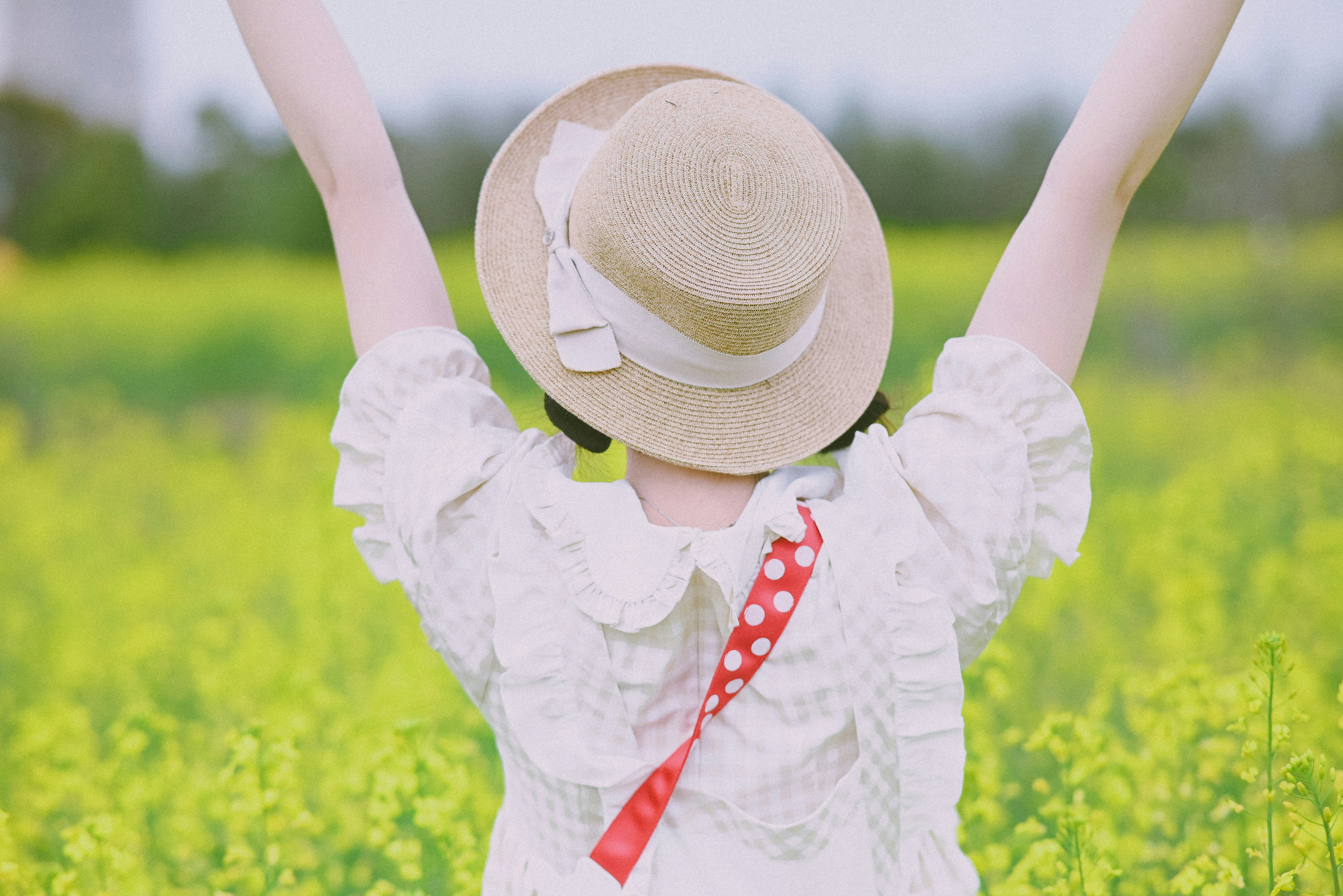 a woman in a hat is standing in a field