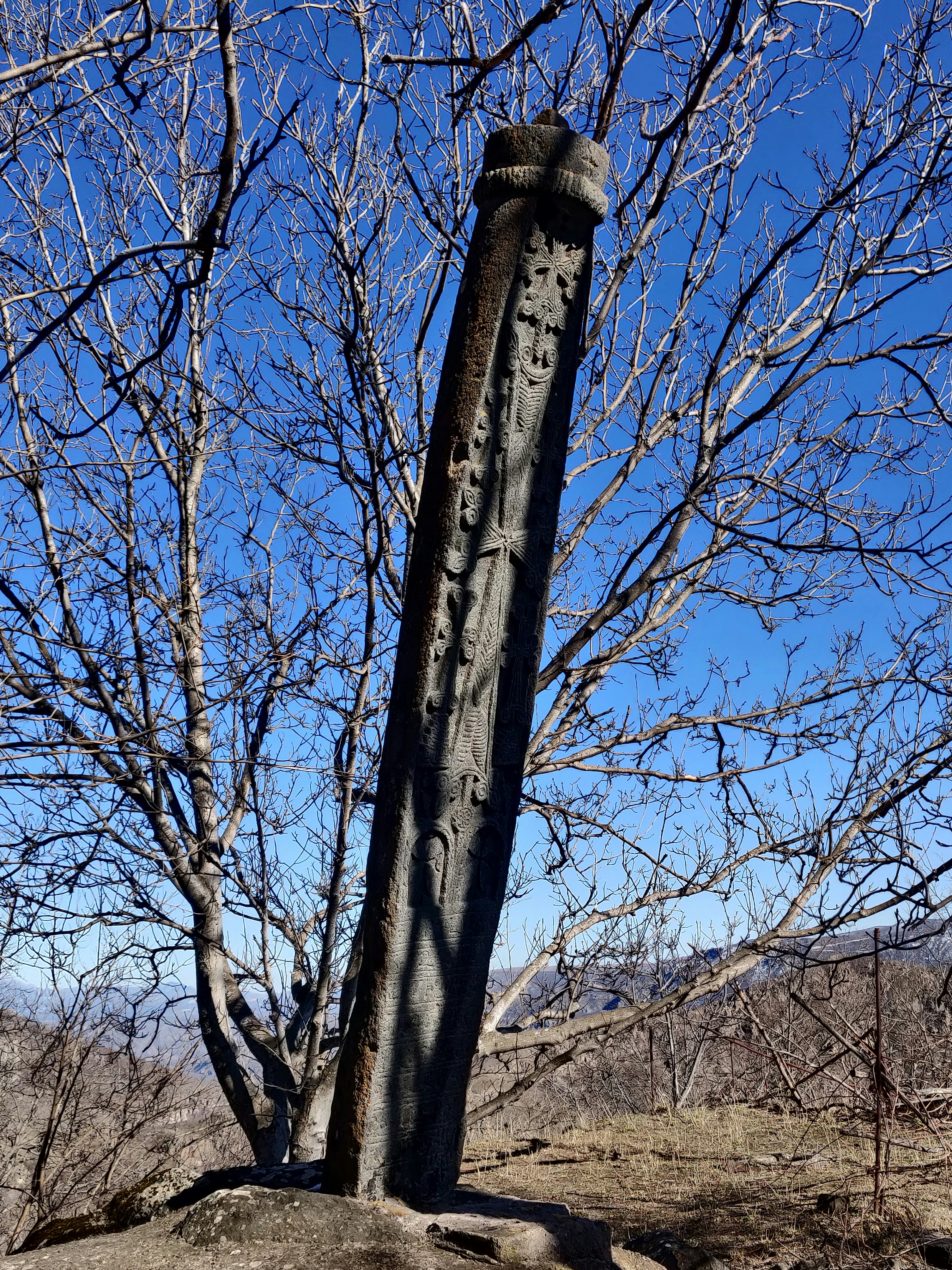Leaning Carved Obelisk Under a Winter-Blue Sky