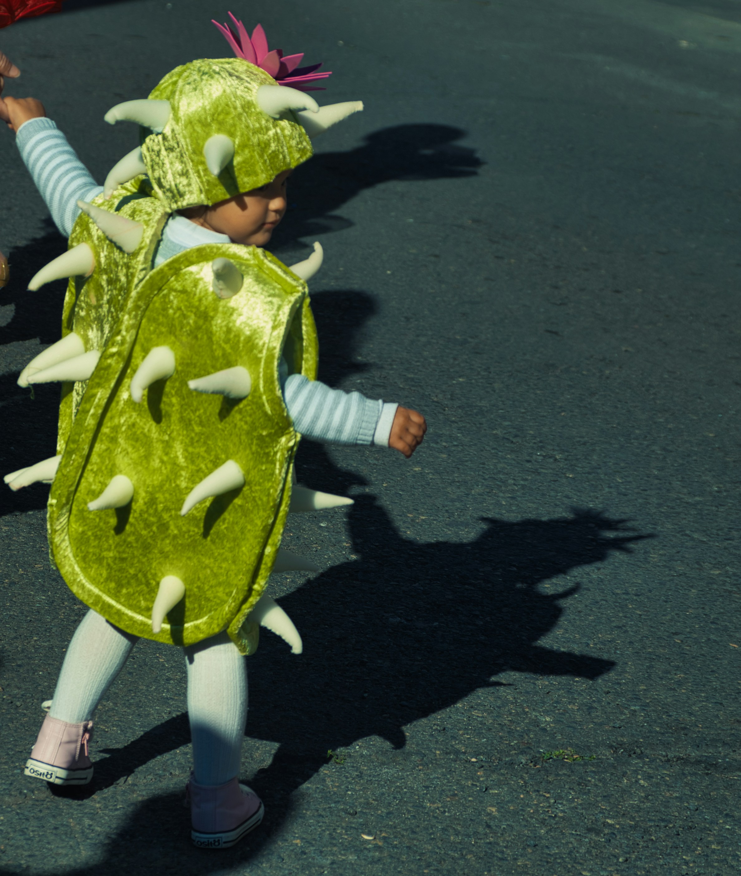 Lime Dragon Parade: A Child in a Spiked Costume Takes a Walk Across the Asphalt