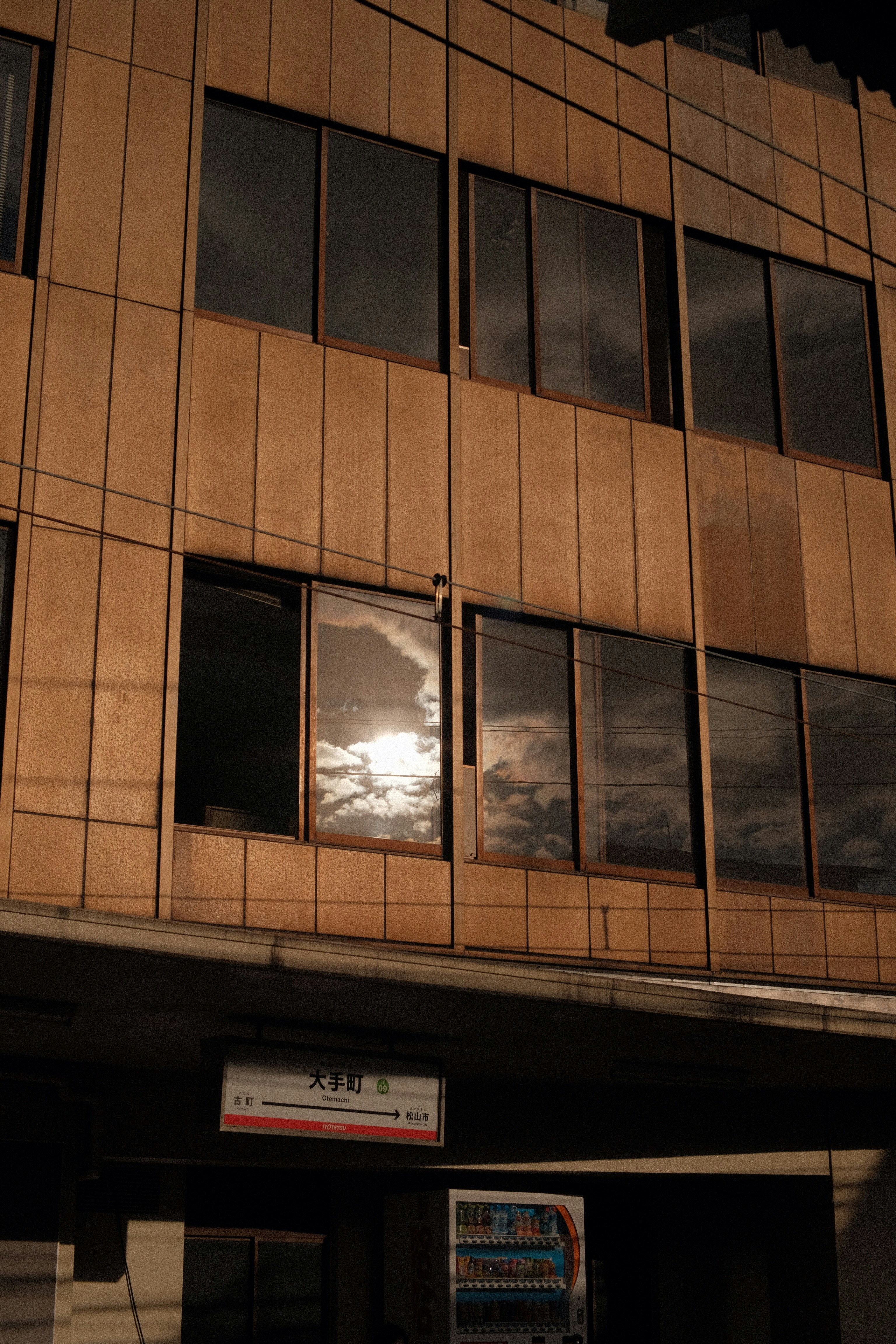 Sunlit Echoes on a Tan Office Facade