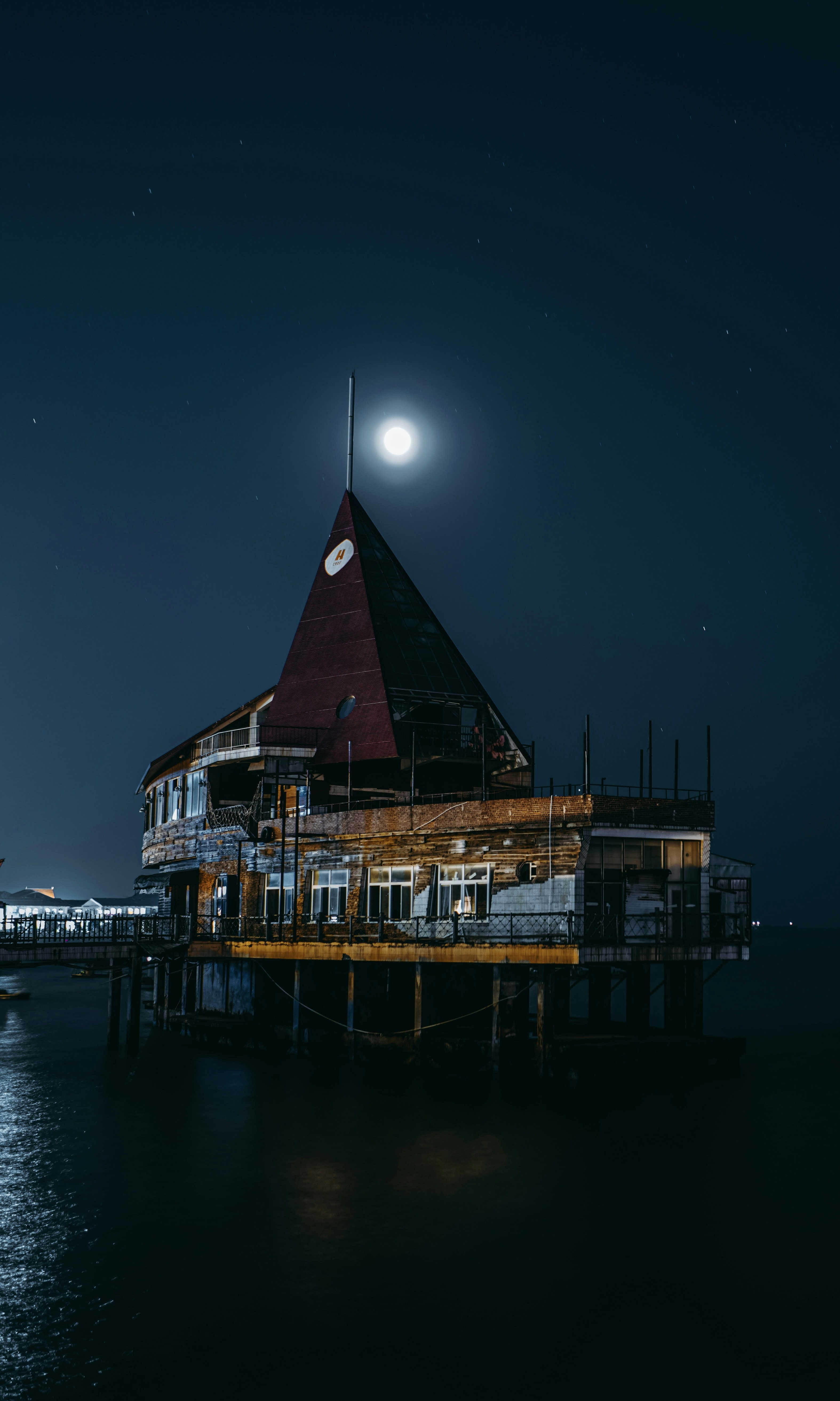 Moonlit A-frame on Stilts: Harbor Timber Under a Quiet Moon