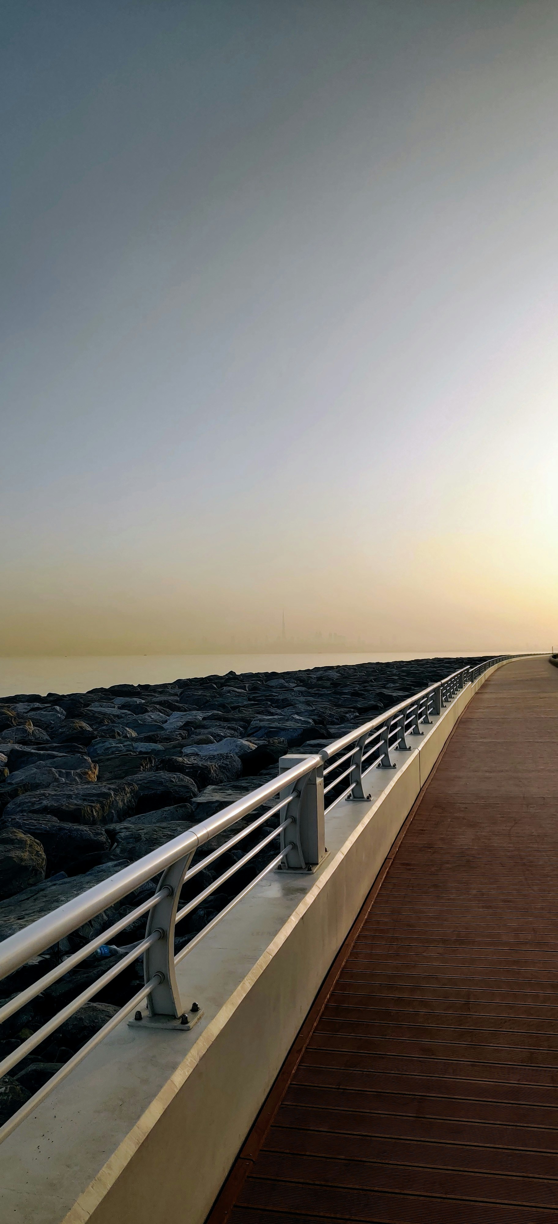 Sunrise Walk Along the Pier: Horizon Quiet on a Calm Sea