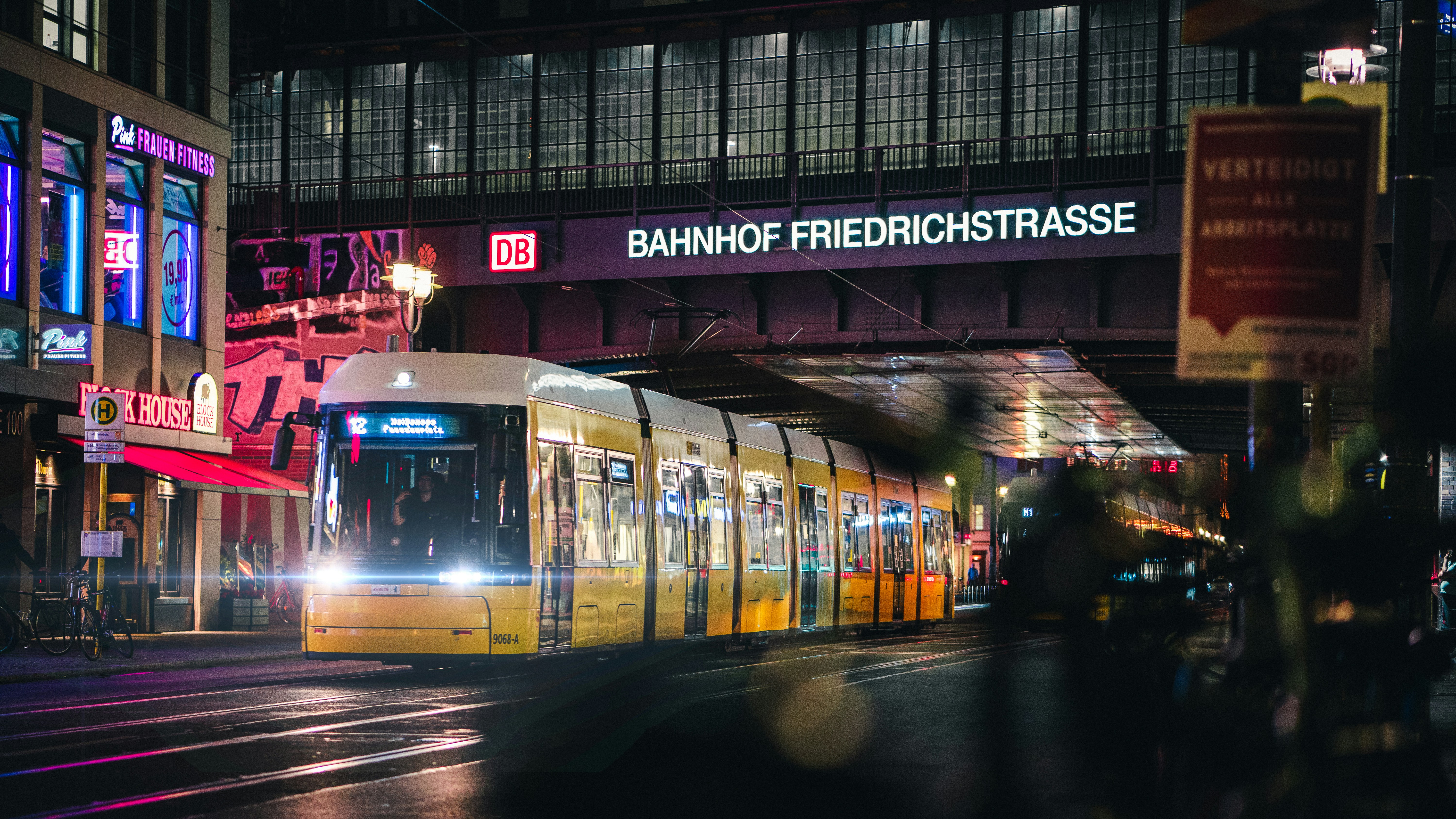 a yellow and white train on a city street