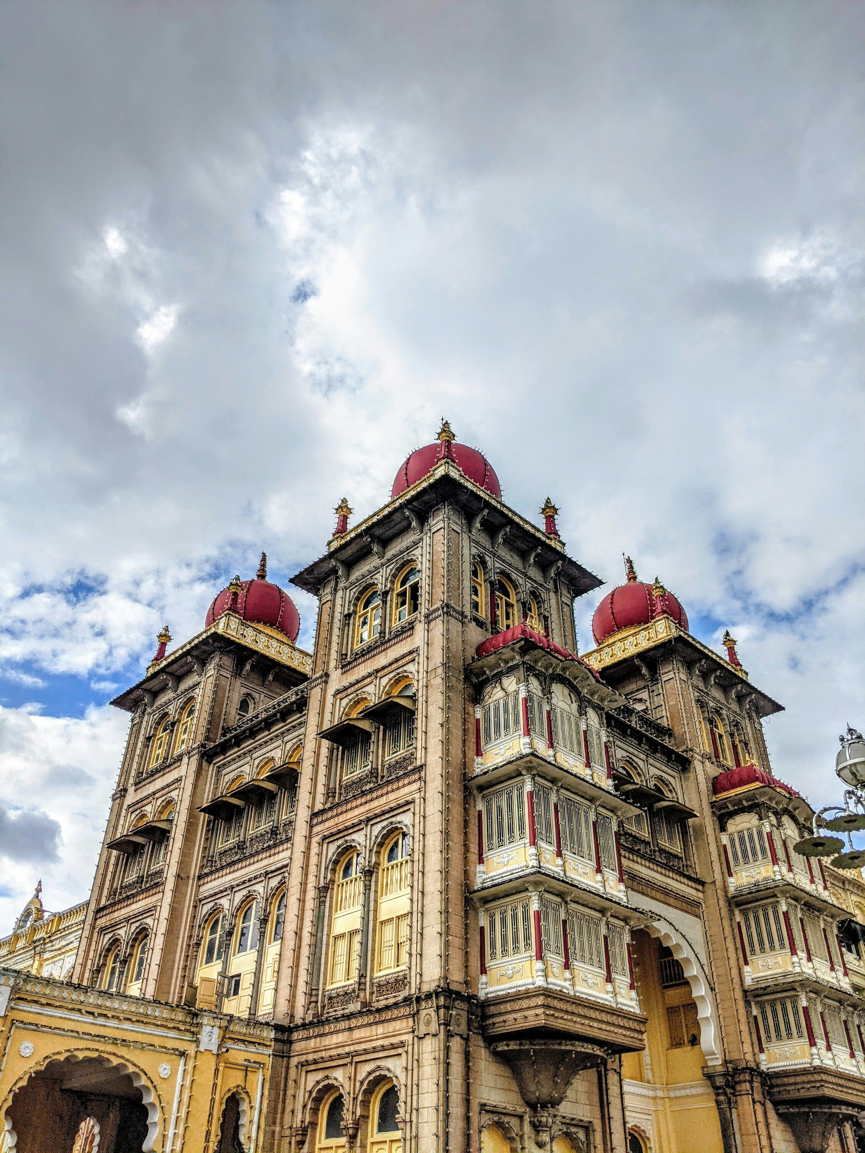 Intricate architectural details of a grand palace with domed towers and ornate balconies against a cloudy sky.