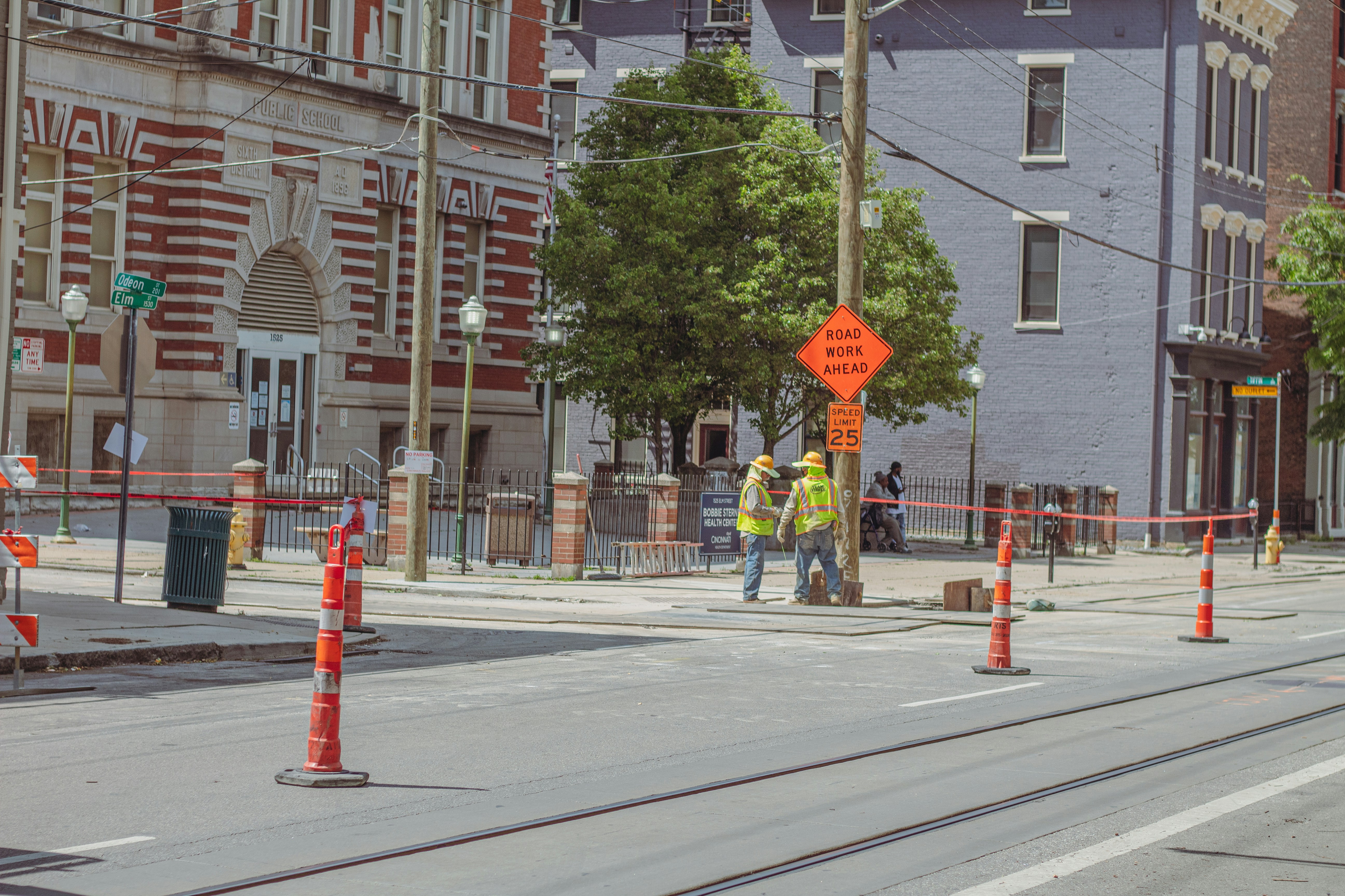 A couple of people standing on a street corner photo – Free Over-the ...