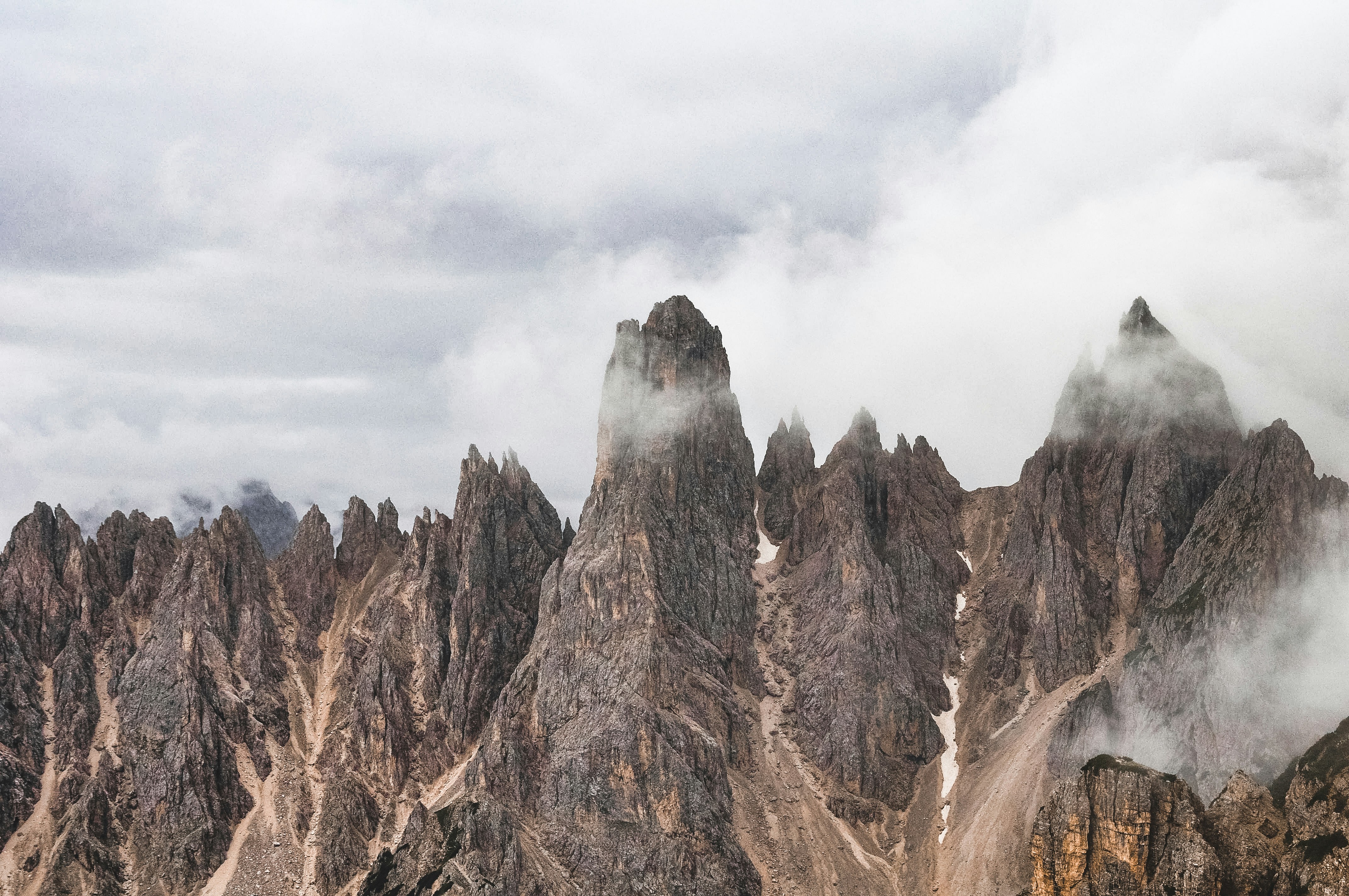 Foto Una cadena montañosa cubierta de nubes y niebla – Imagen Grigio ...