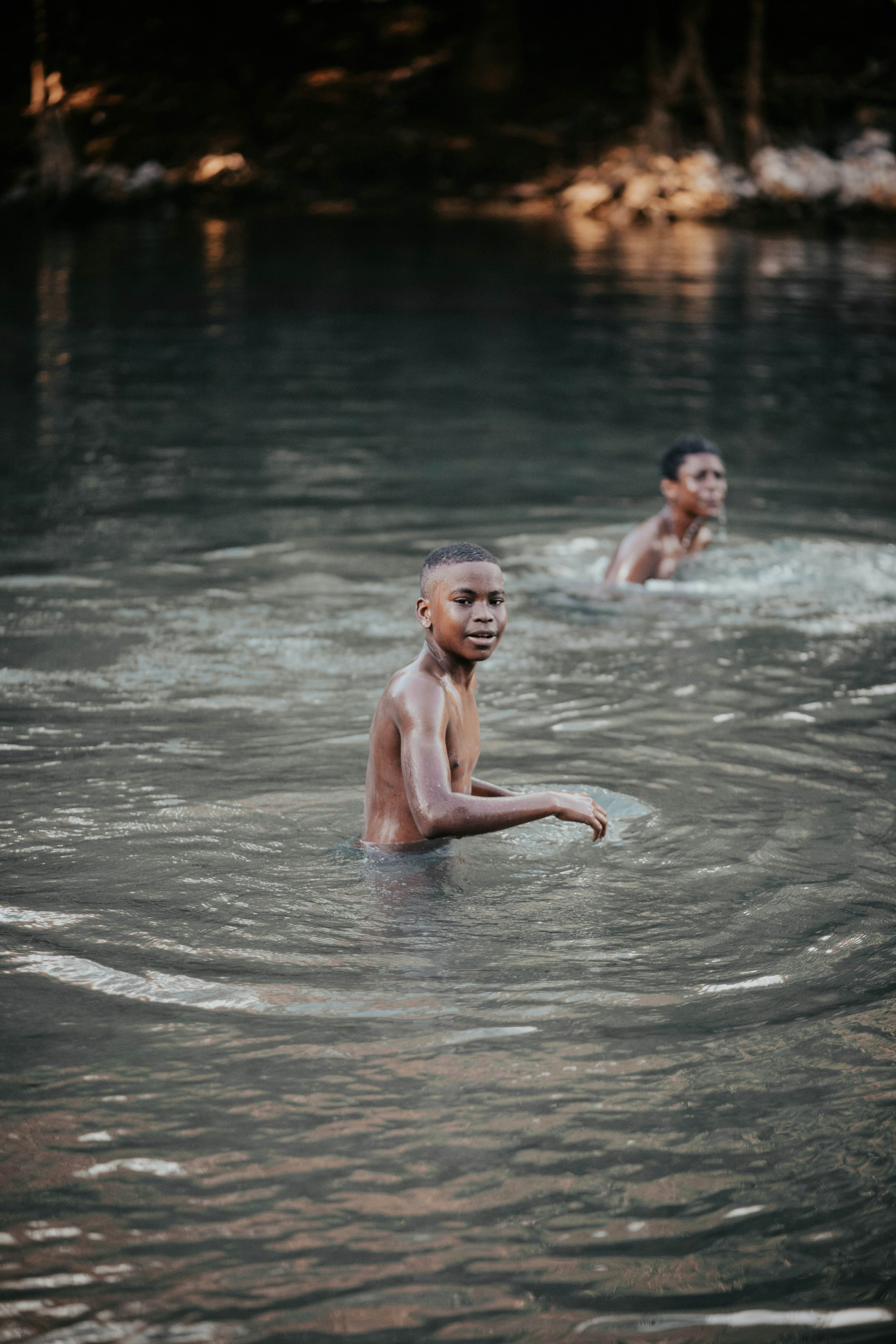 Two people swimming in a body of water photo – Free River Image on Unsplash
