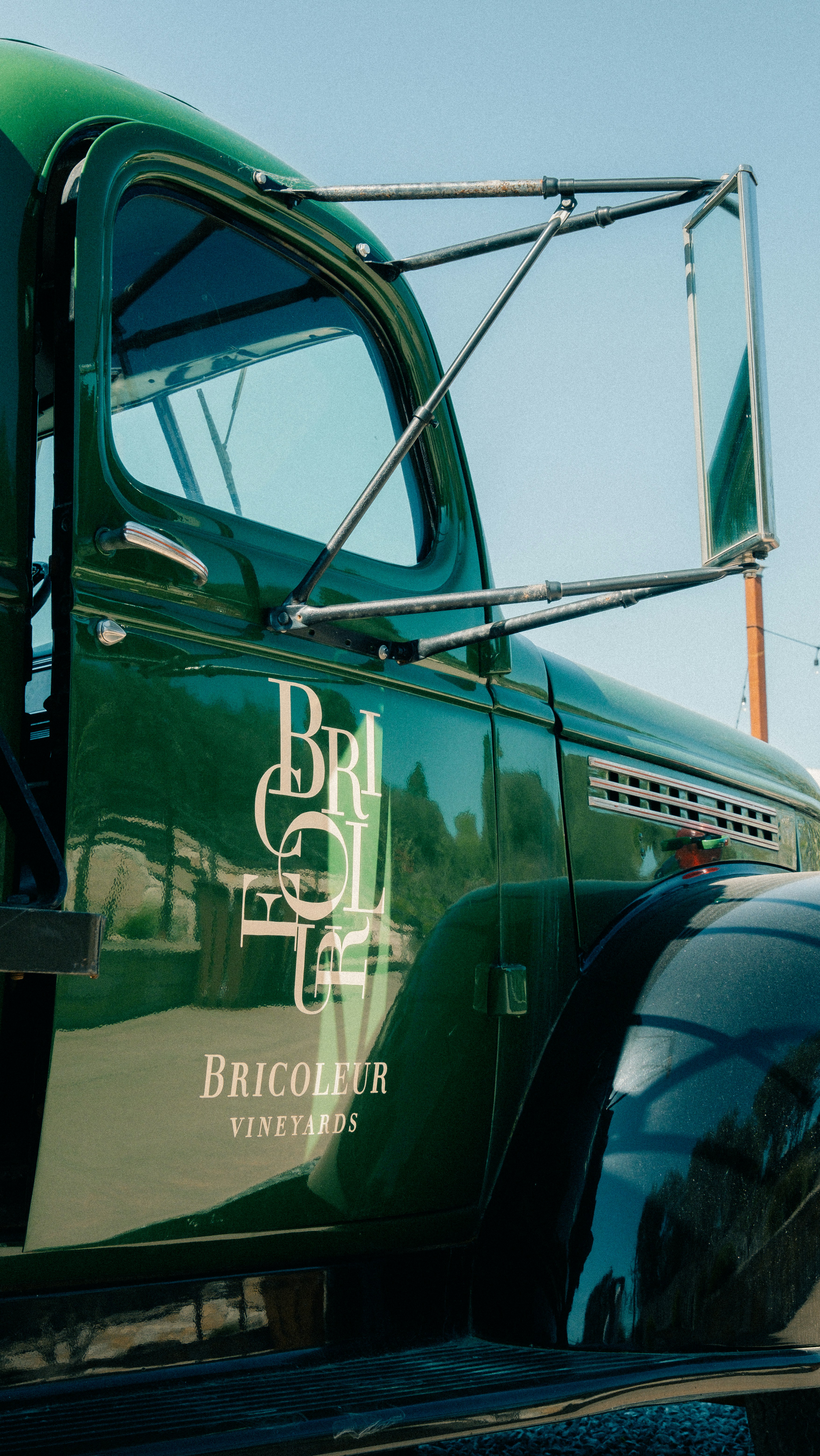Bricoleur Vineyards Emblem on a Sunlit Green Vintage Truck