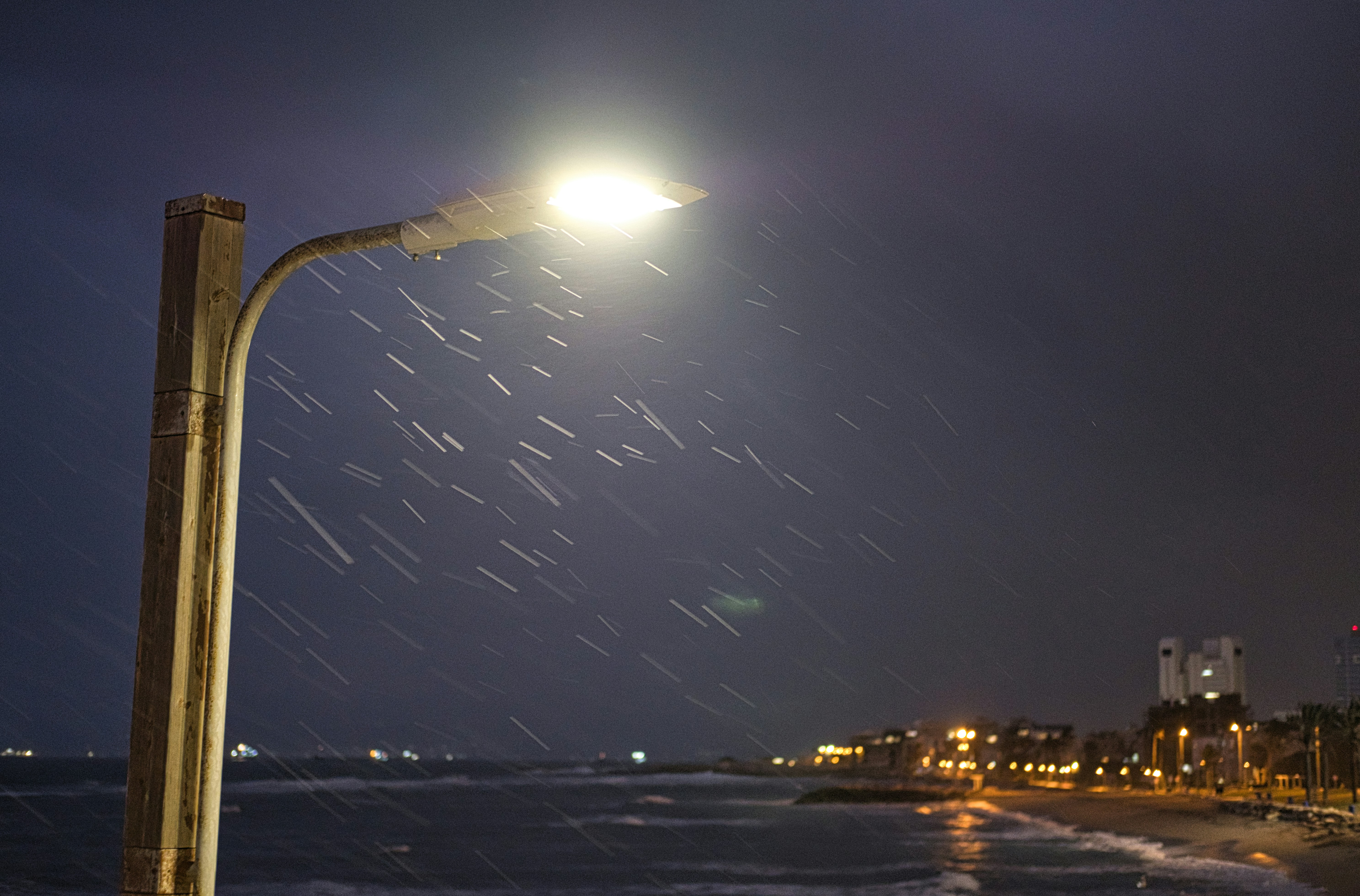 a street light on a pole next to the ocean