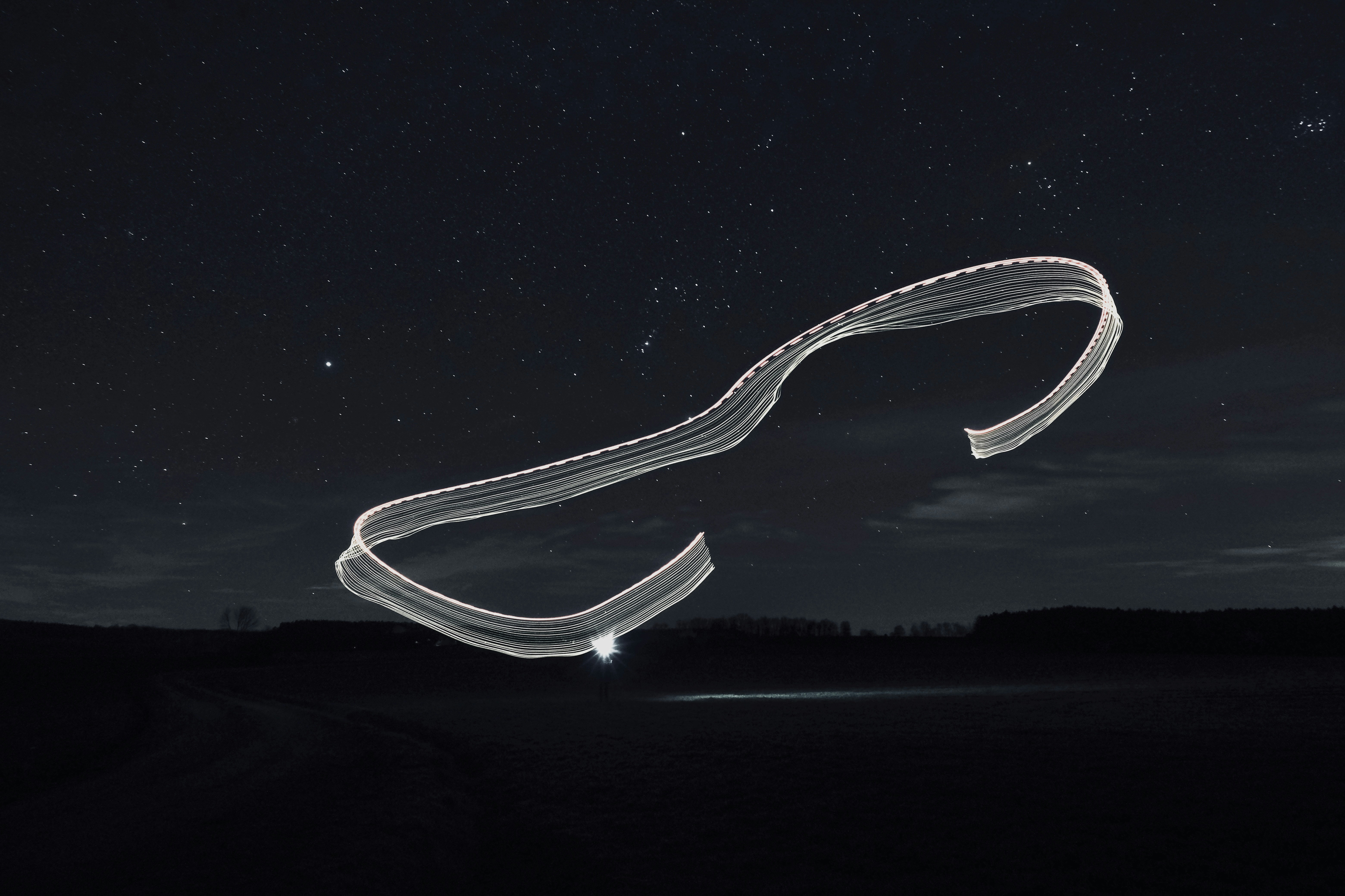 Infinity in Motion: A Light Ribbon Hovering Over a Silent Nightscape