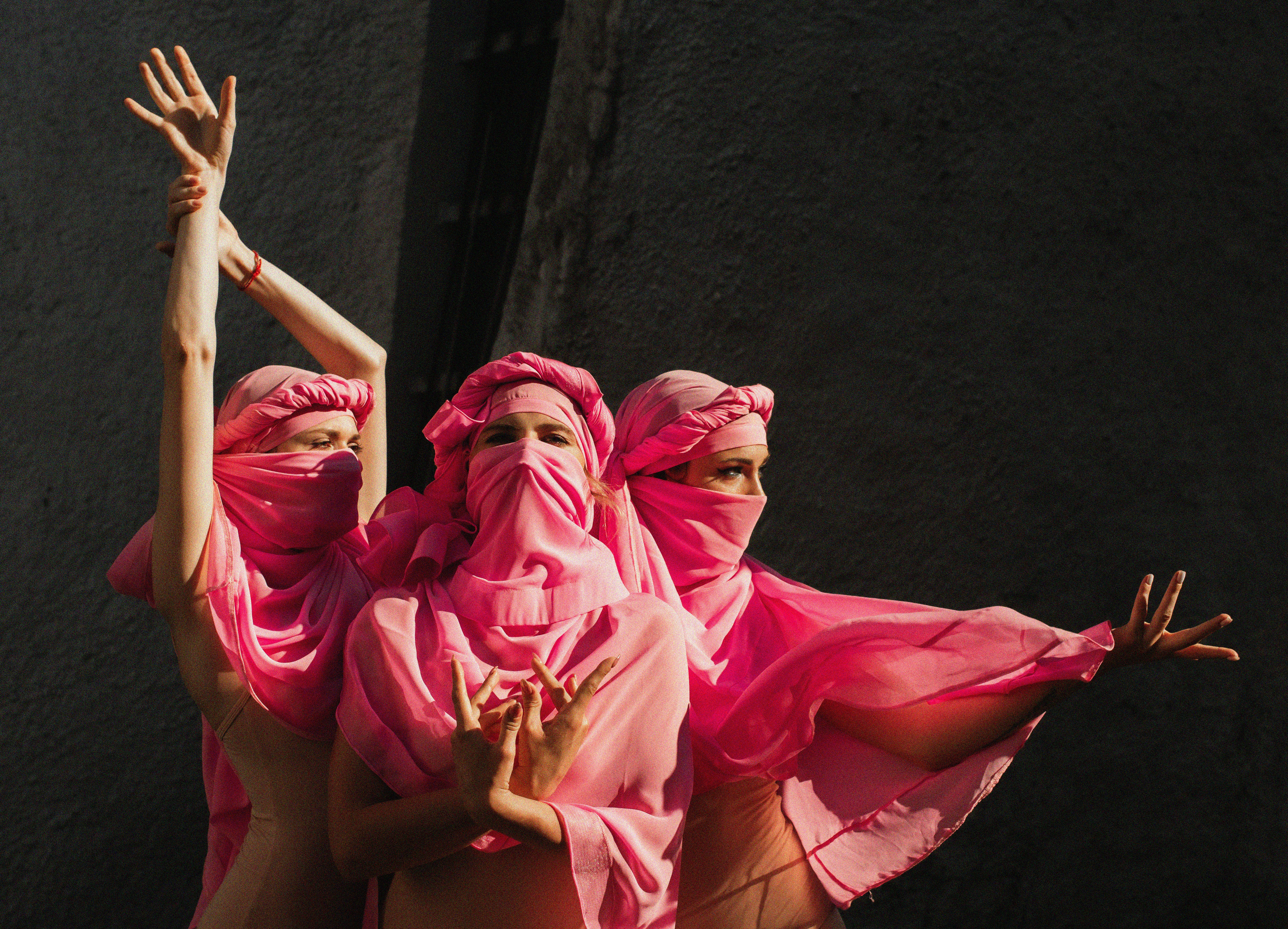 Pink Veils in Motion: A Trio of Dancers in Draped Silence