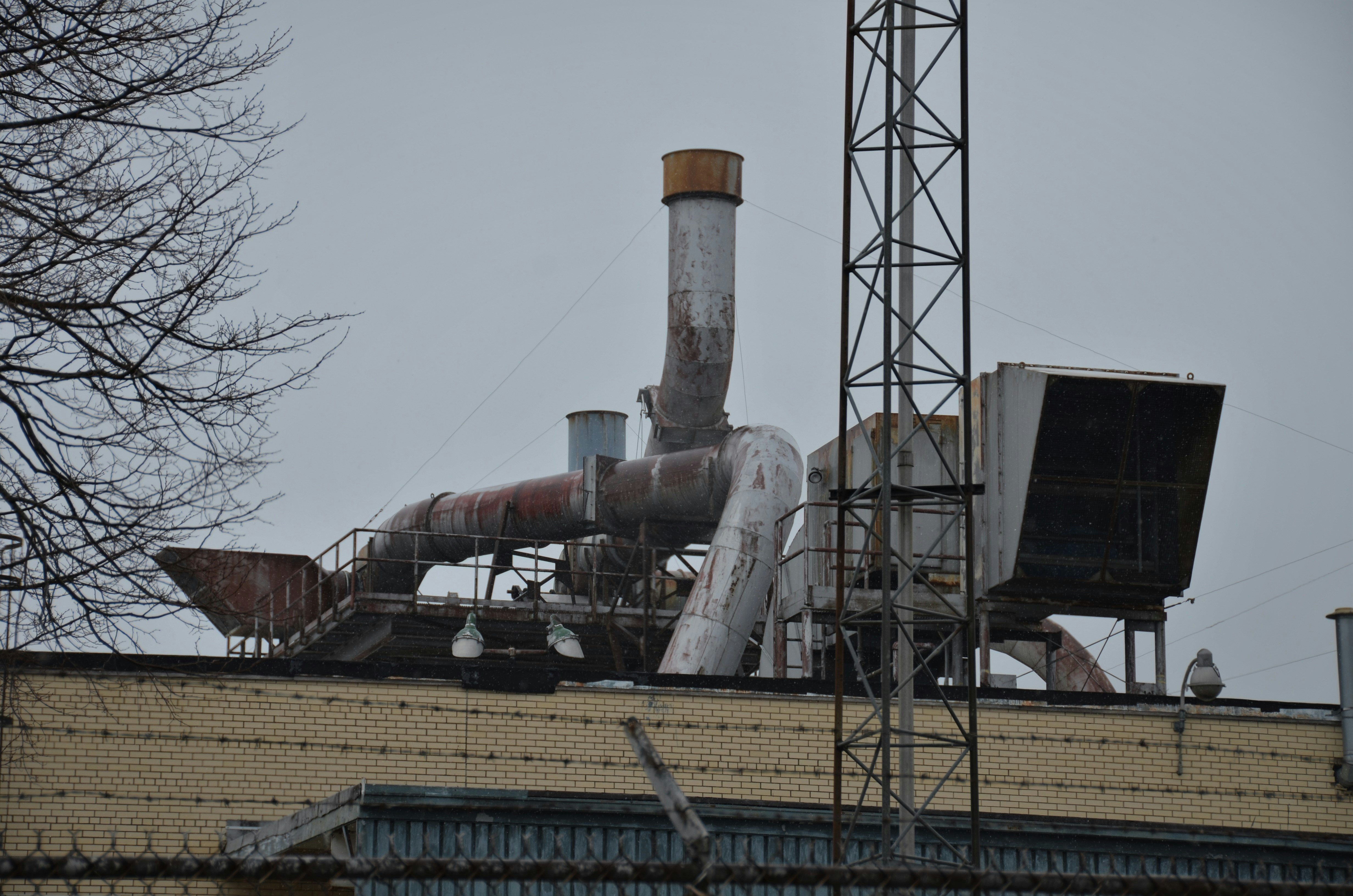 Iron Skyline: Rusted Ductwork Against a Cloudy Roofscape