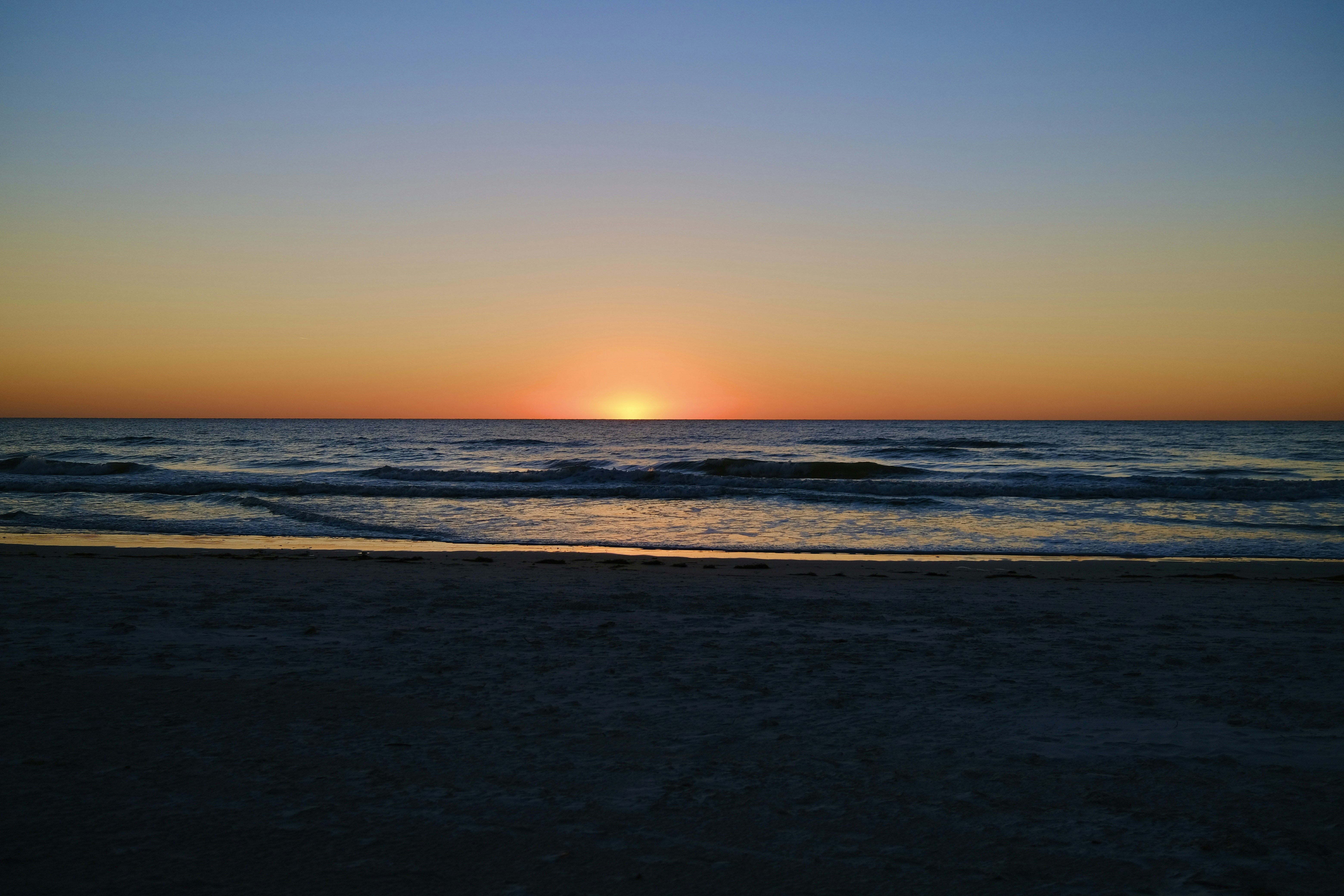 The sun is setting over the ocean on the beach photo – Free Clearwater ...