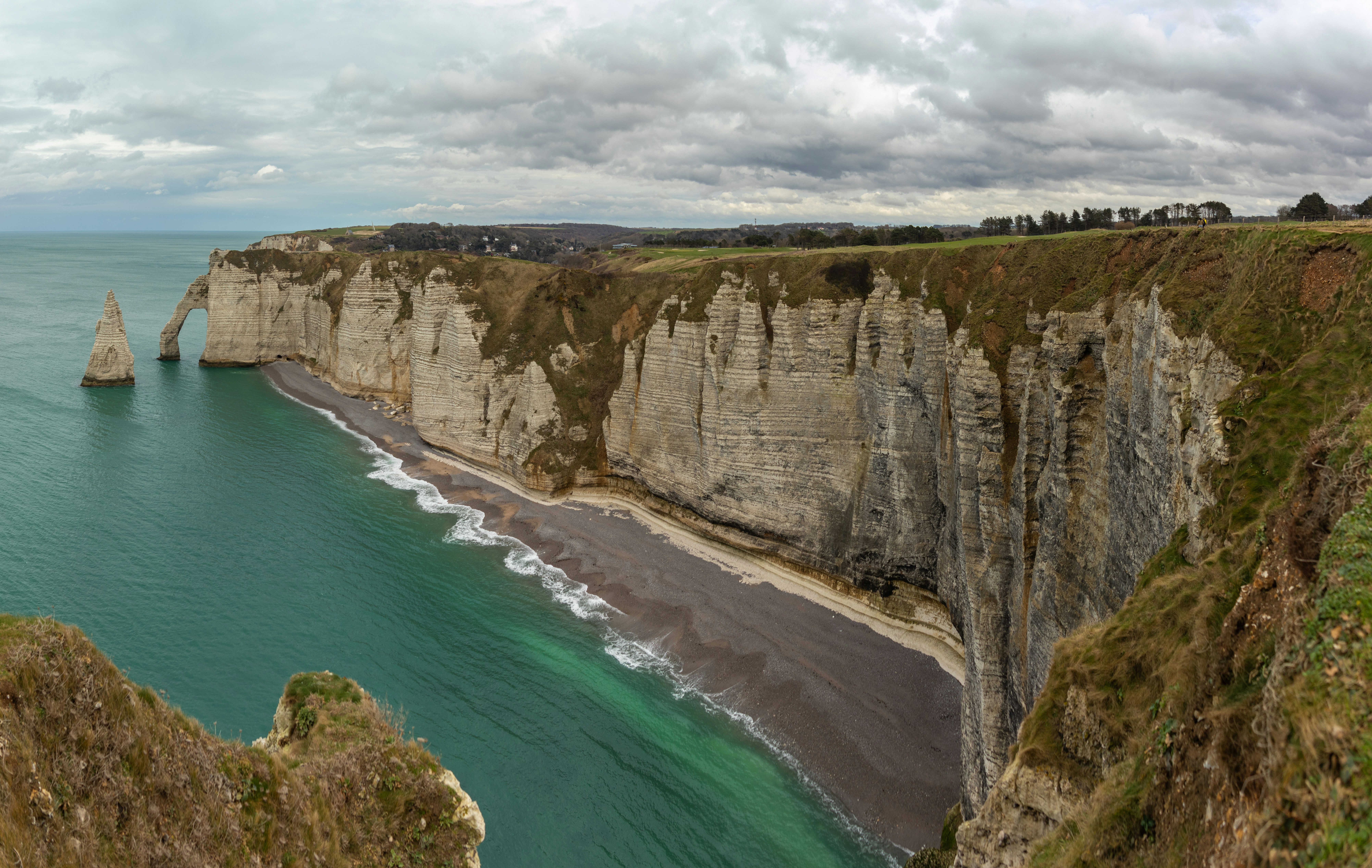Chalk Arch at the Sea Edge: Turquoise Water and Cloudy Cliffs