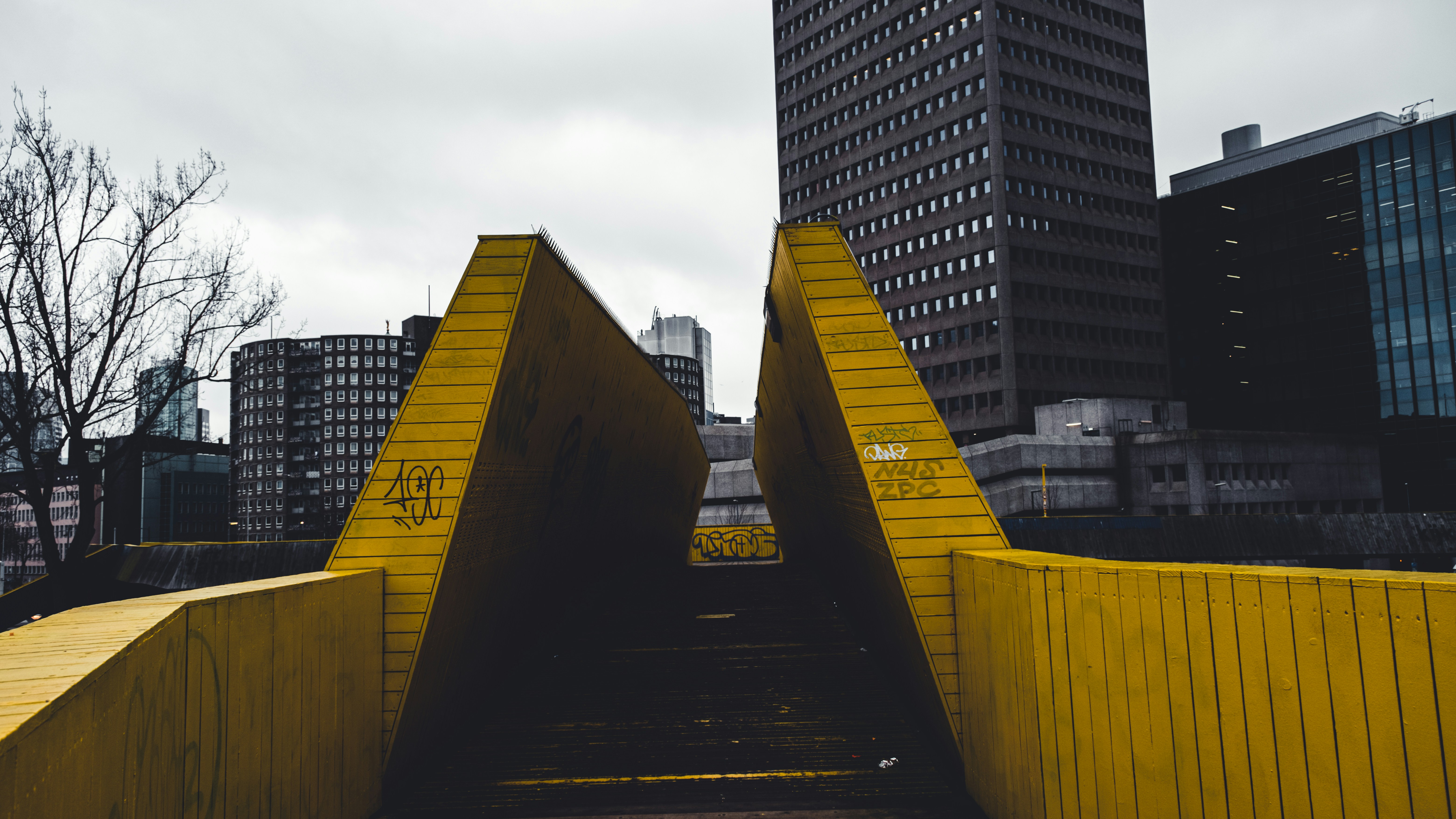 A very tall building next to a yellow ramp photo – Free Architecture ...