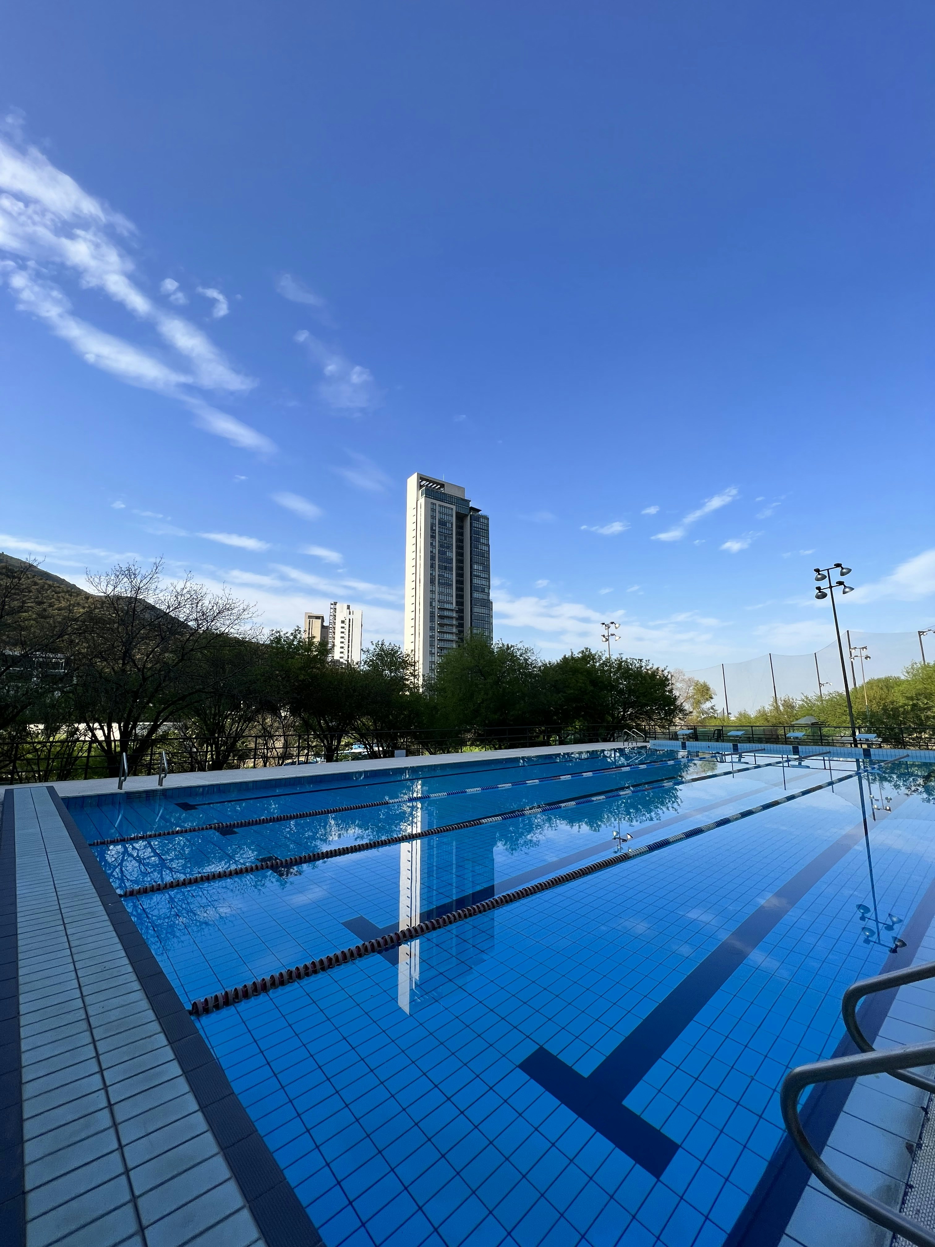 an empty swimming pool with a tall building in the background