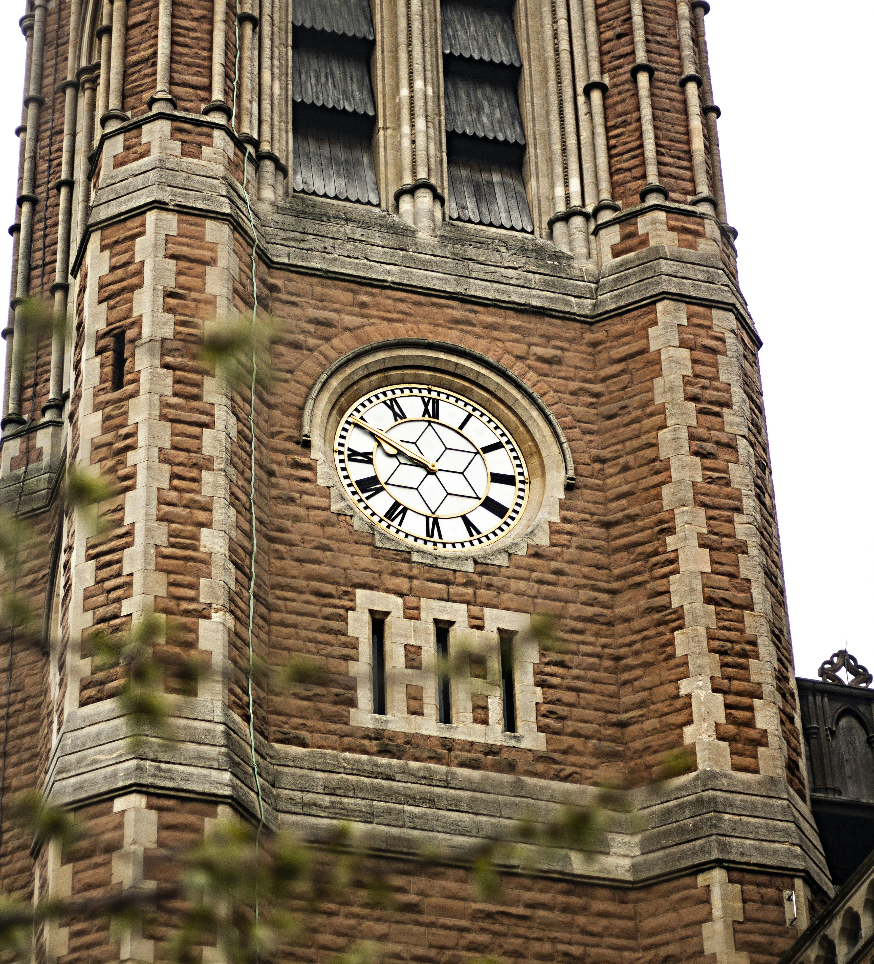 A large brick clock tower with a clock on each of it's sides photo ...