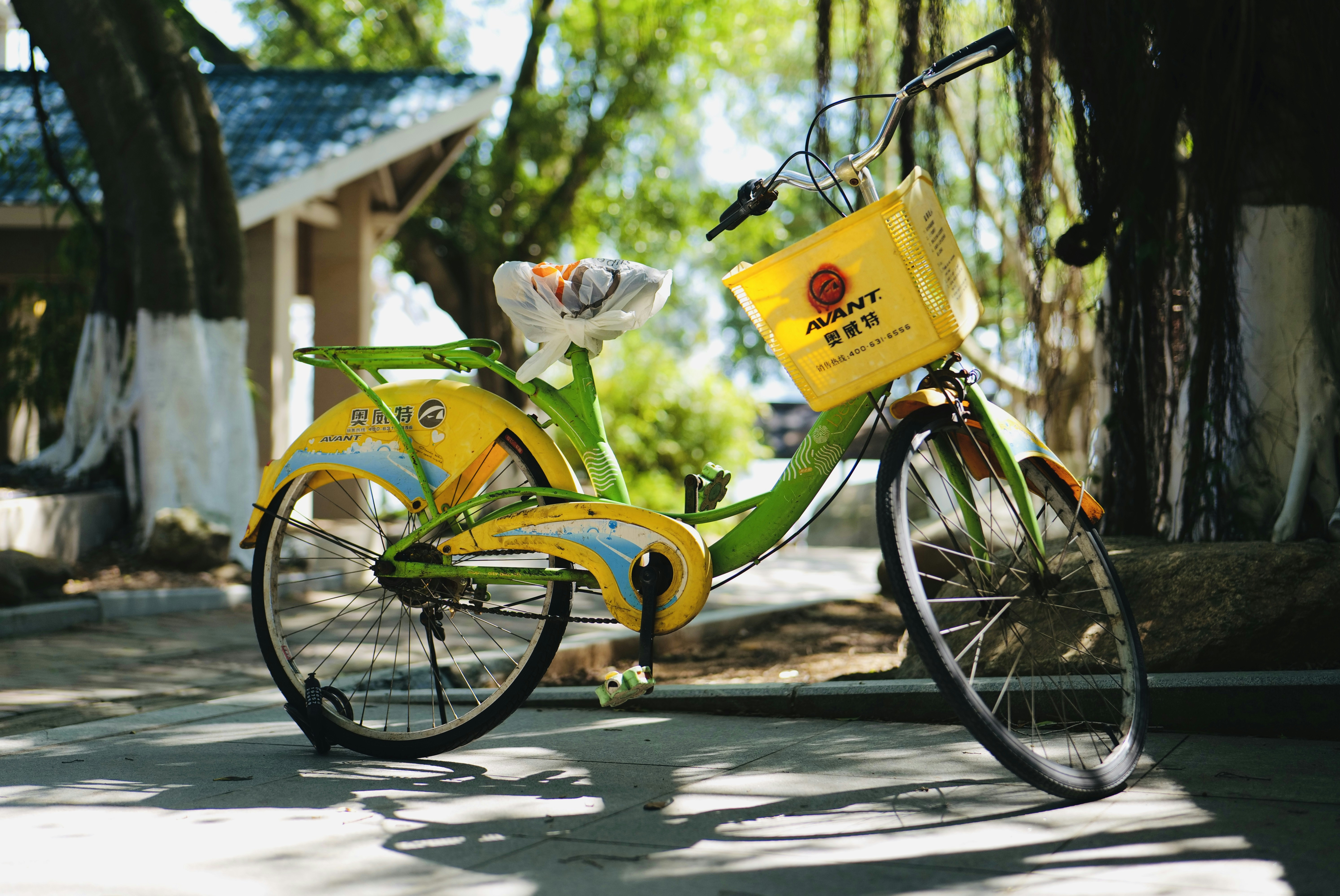 A yellow bicycle parked on the side of a road photo – Free Bike Image ...