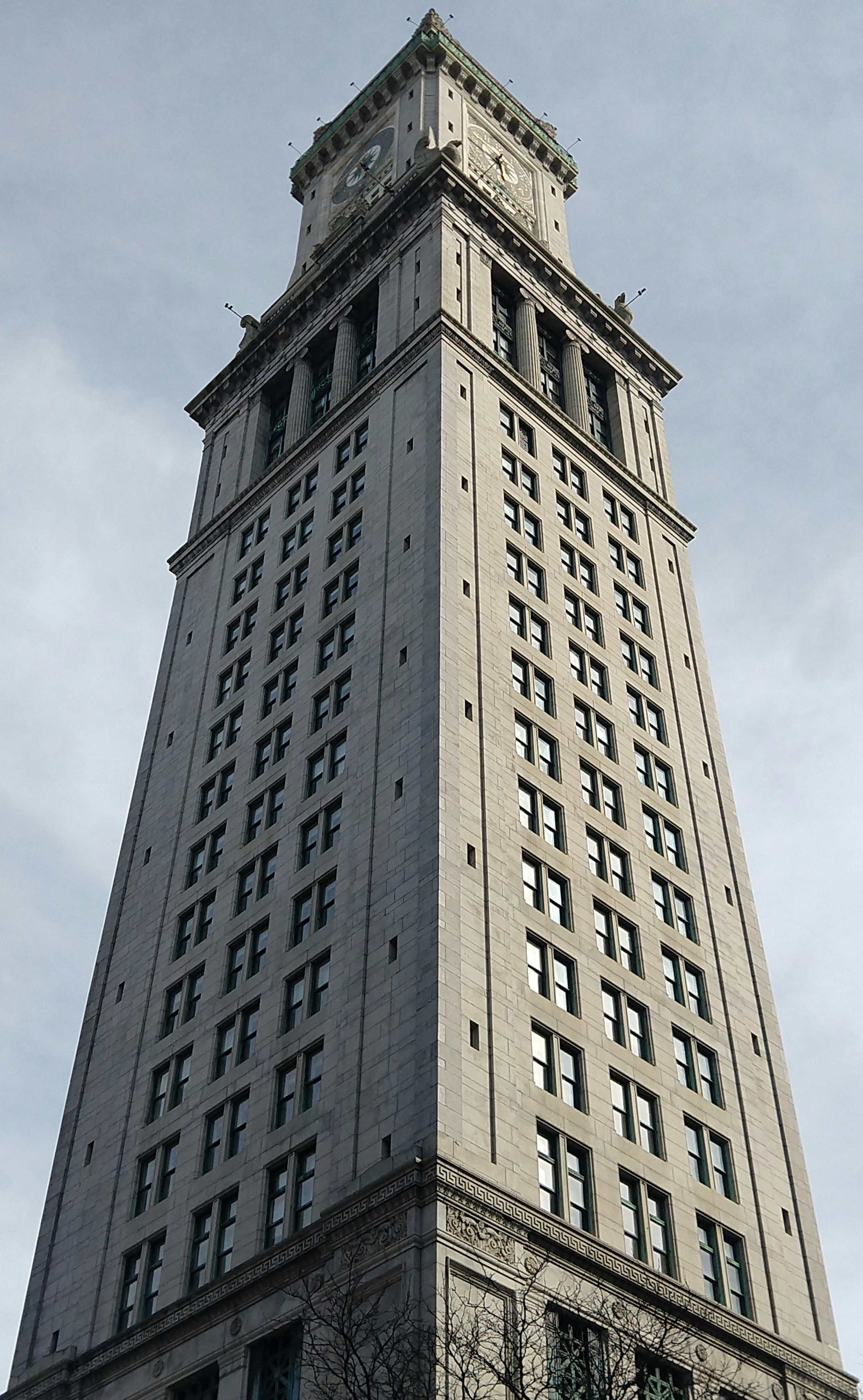 Historic clock tower rising dramatically against a cloudy sky, showcasing intricate architectural details.