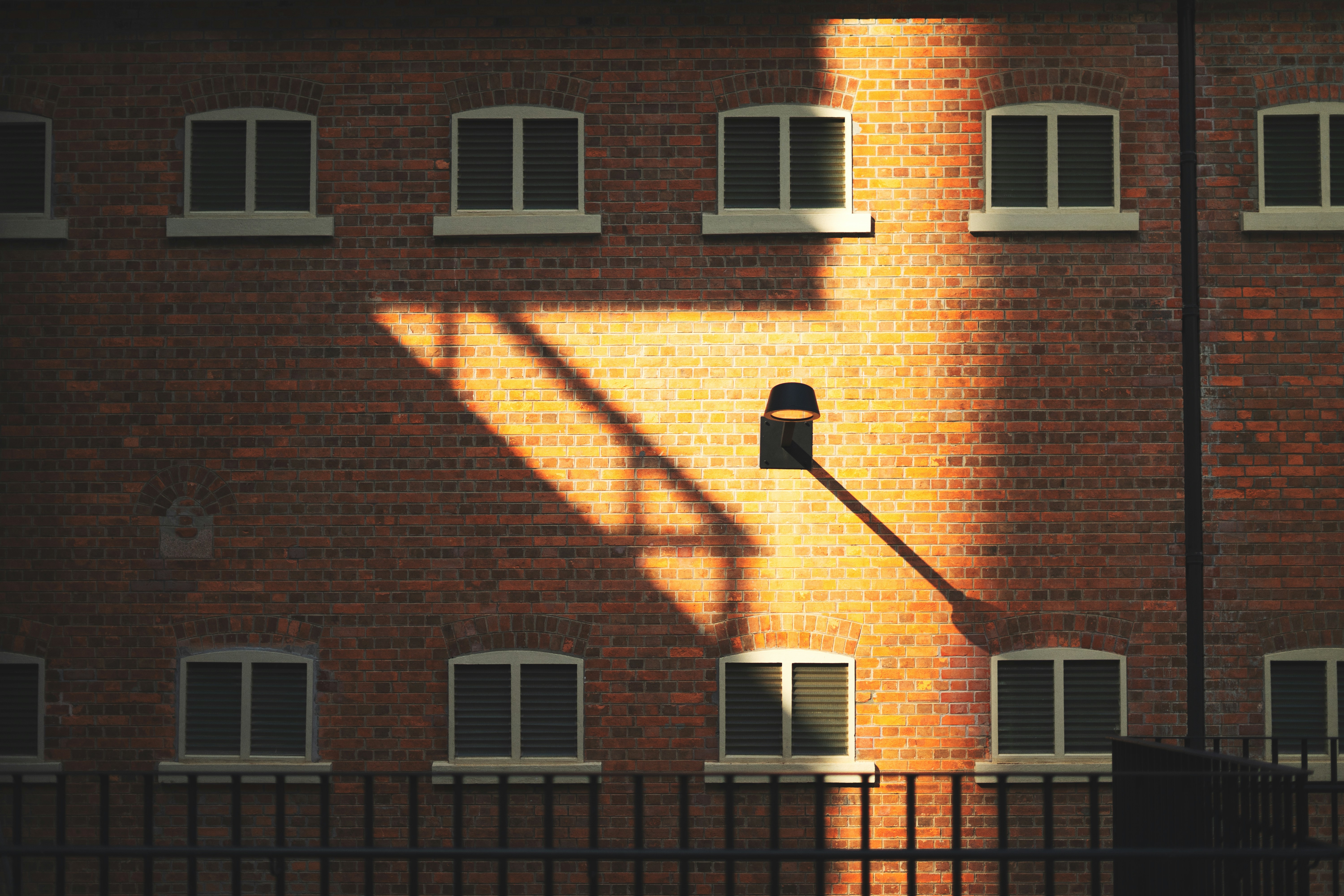 The shadow of a street light on a brick building photo – Free Appliance ...
