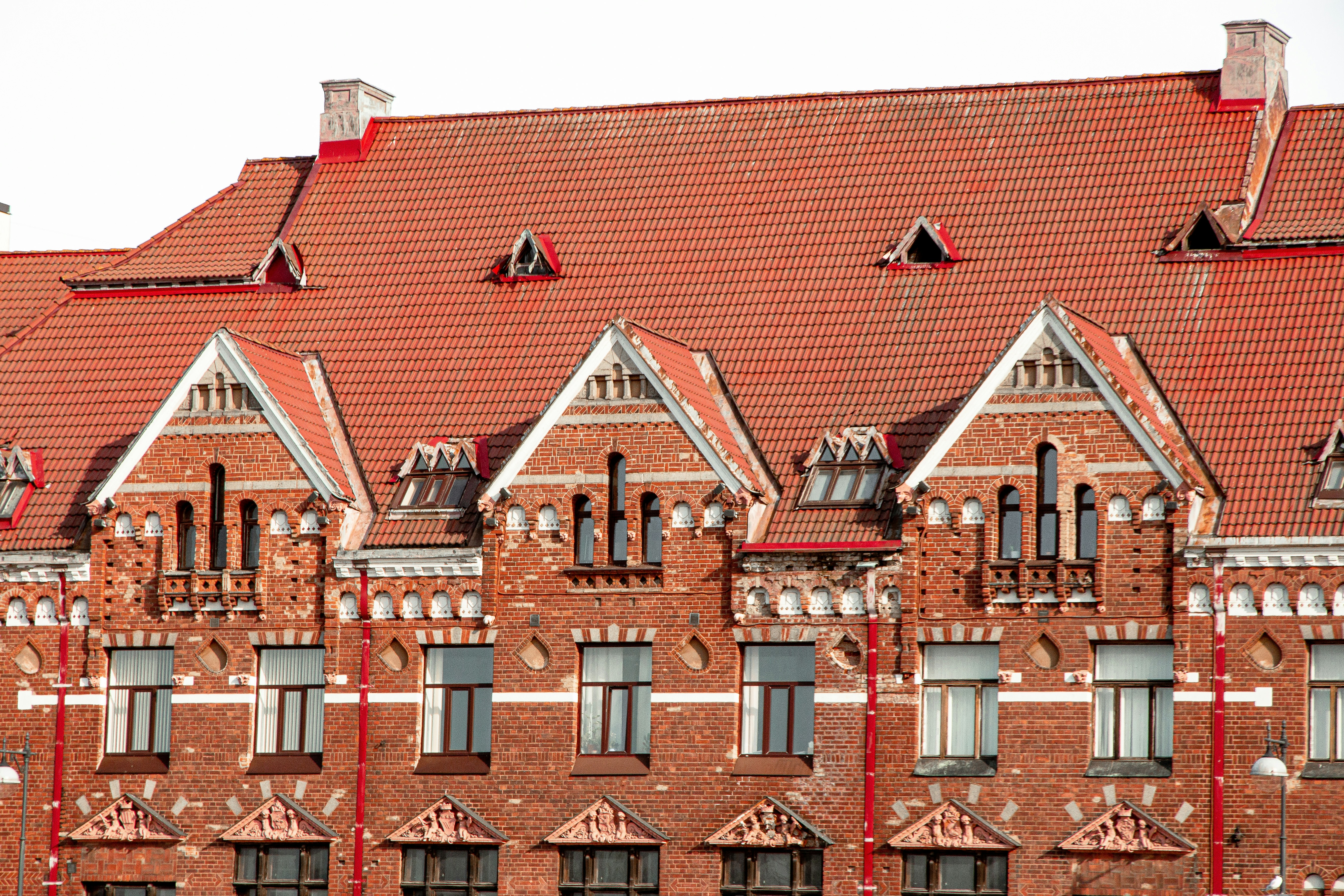 Historic building with intricate red brickwork and steep gabled roofs.