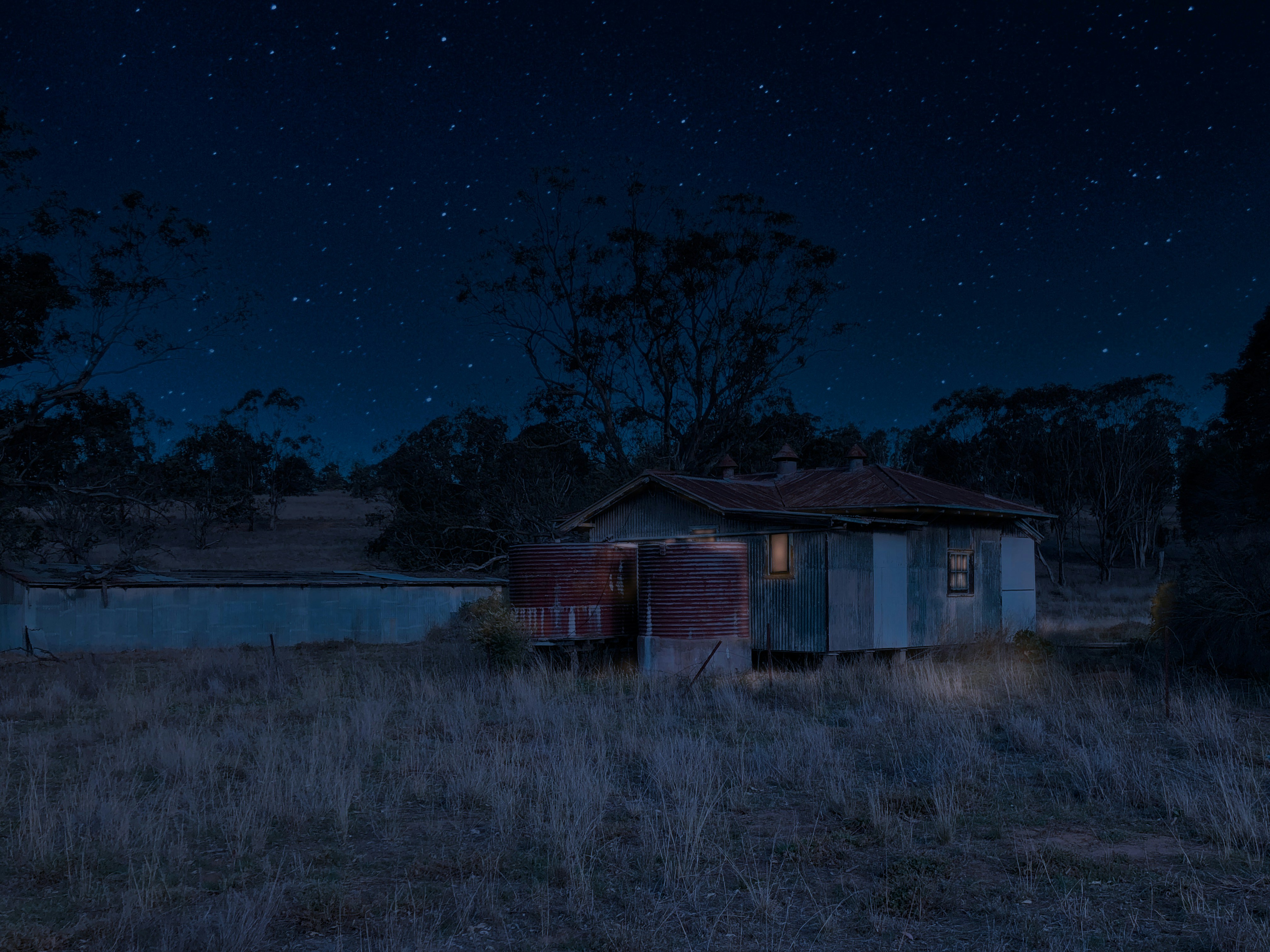 An old run down shack in a field at night photo – Free Black Image on ...
