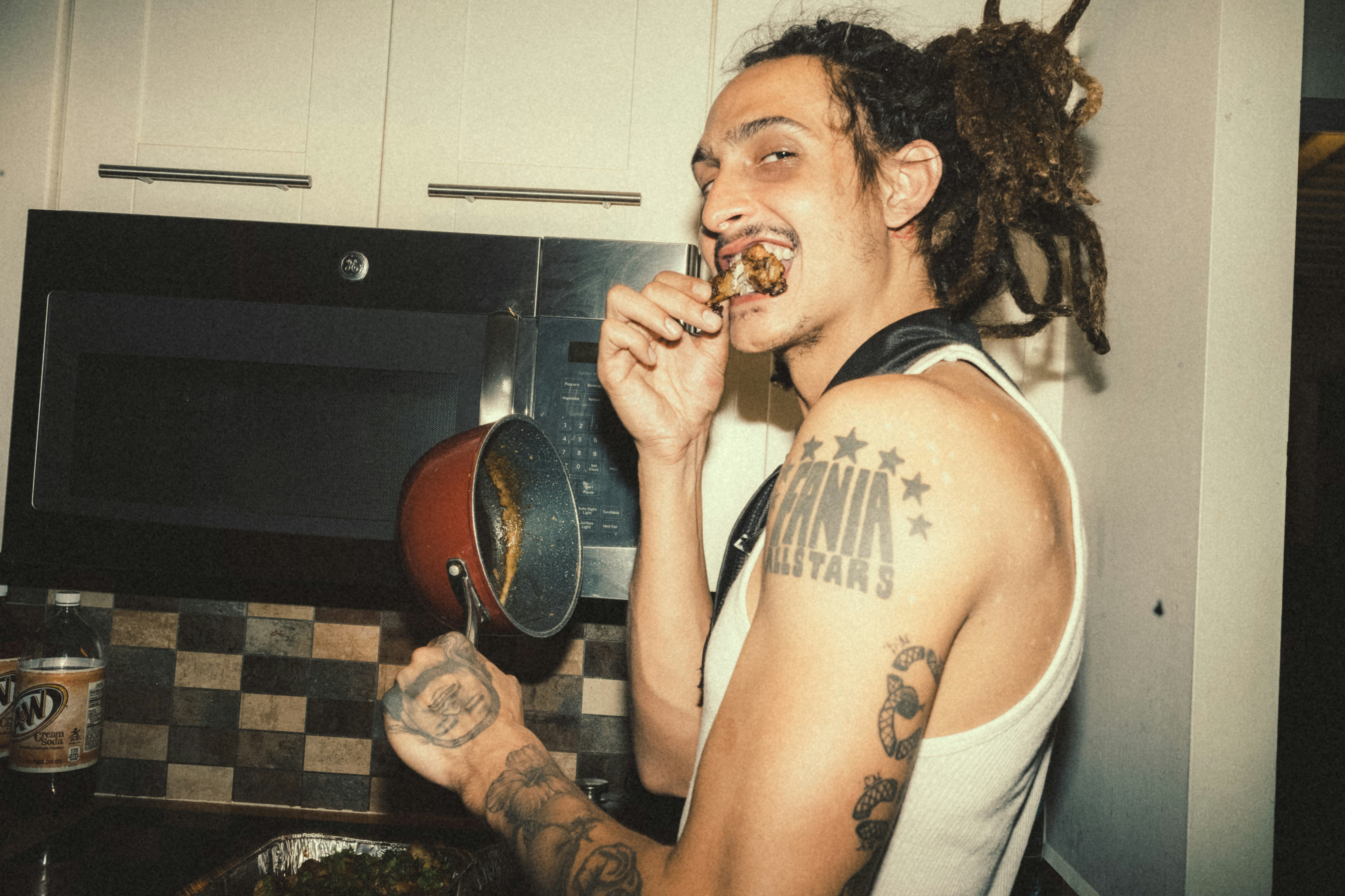 A man with dreadlocks eating food in a kitchen photo – Free Grey Image ...