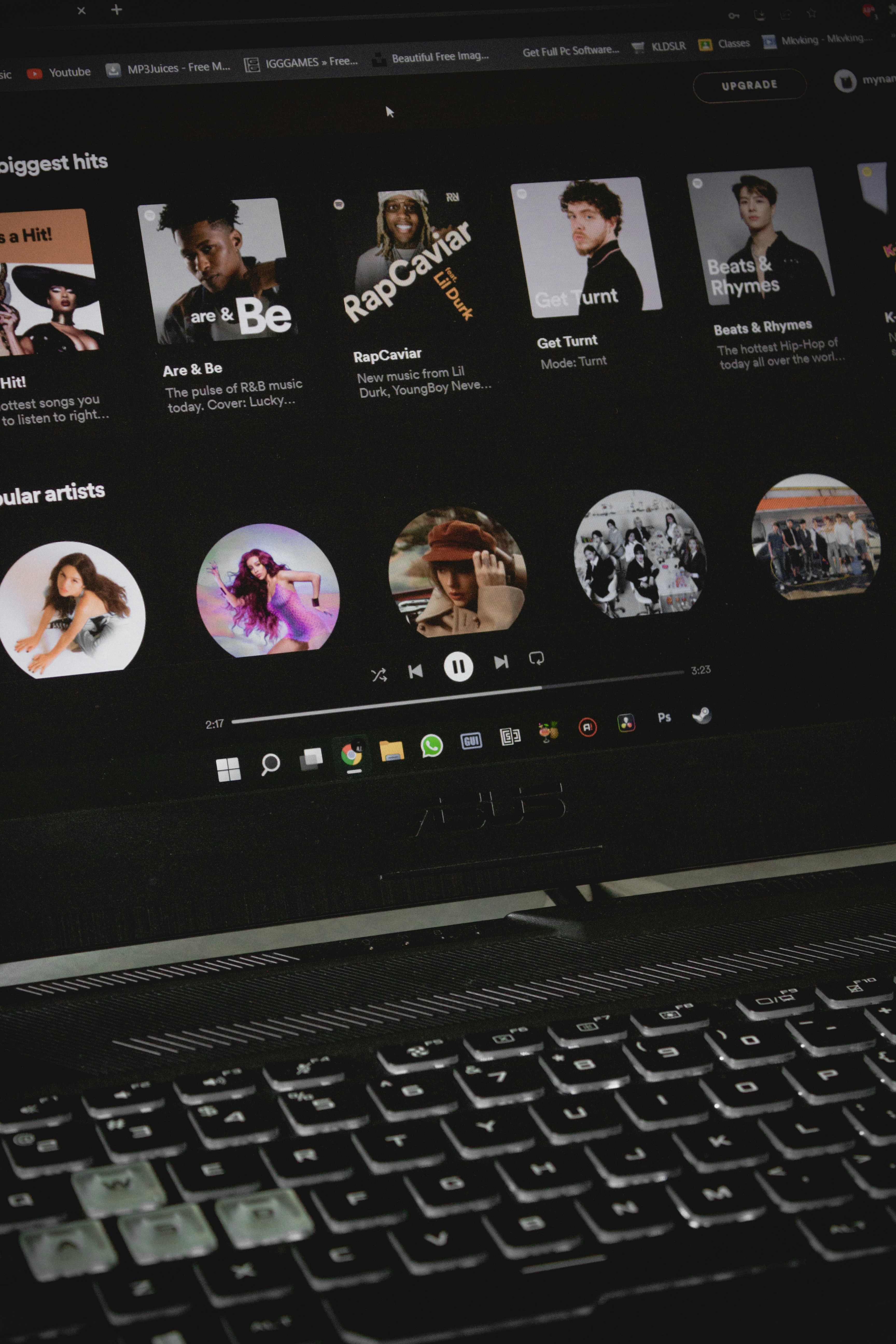 Spotify interface displaying popular music playlists and artists on a laptop screen, highlighting the modern music experience.