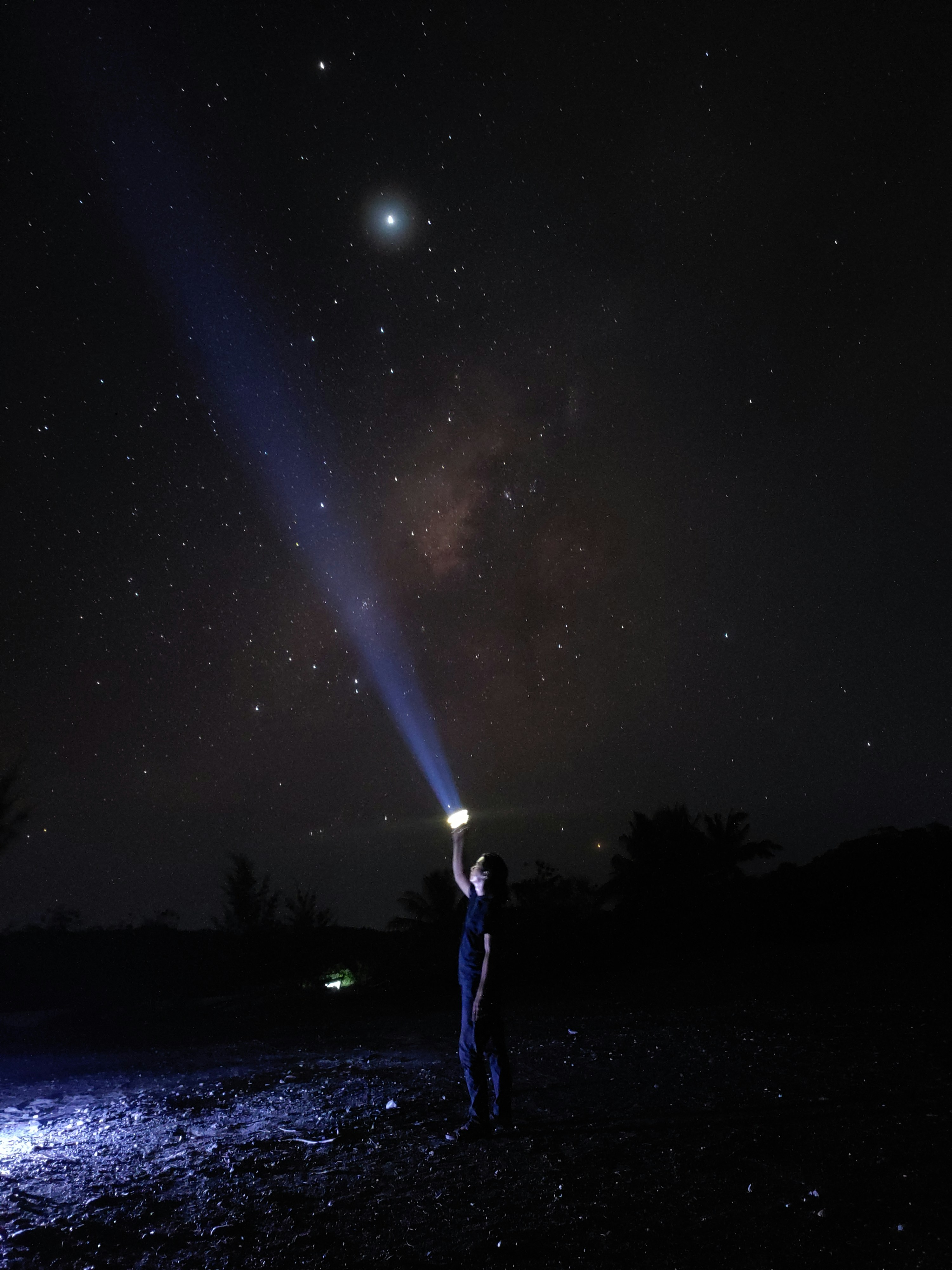 A man holding a flashlight up to the sky photo – Free Space Image on ...