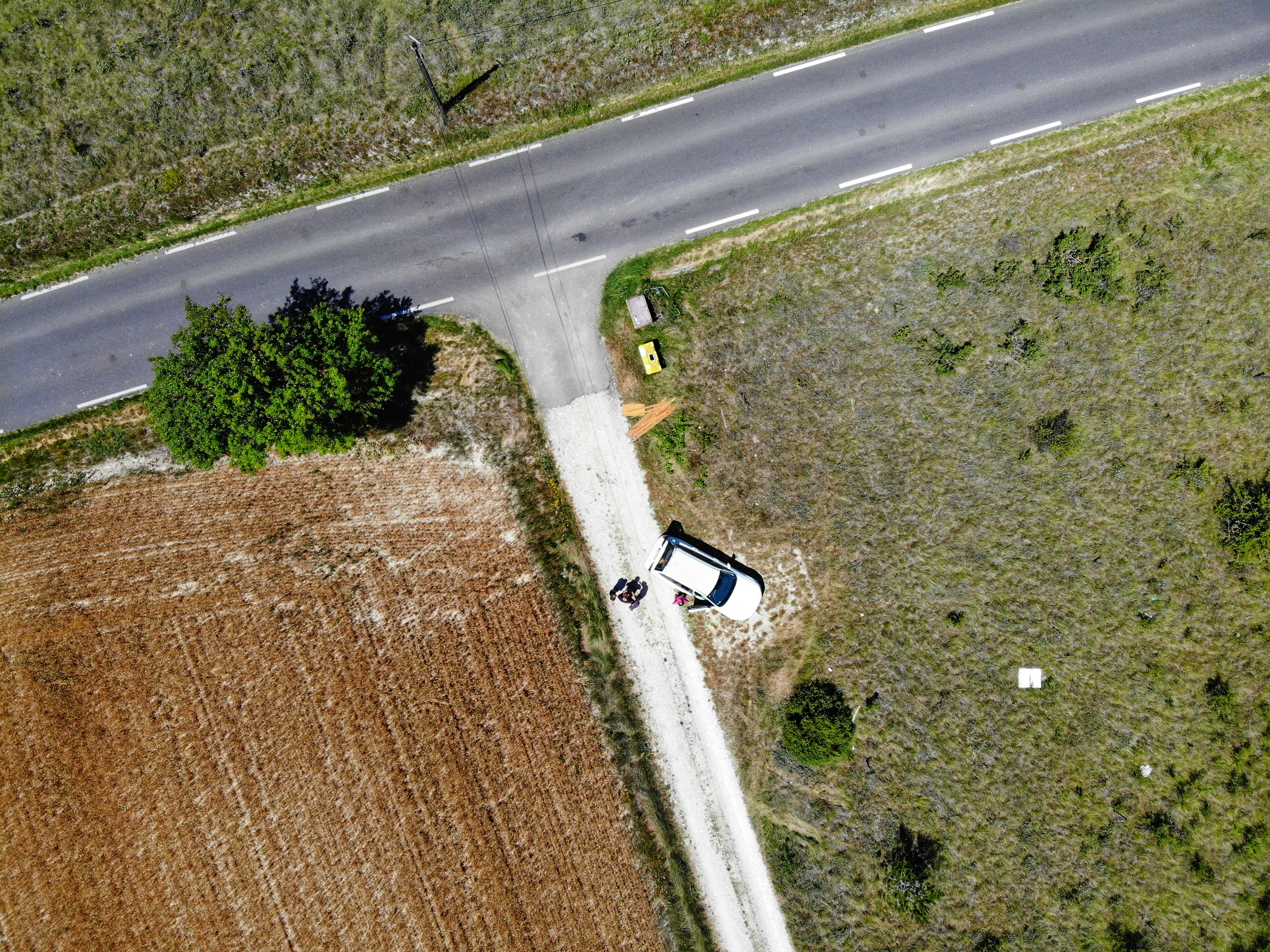 Dusty Crossroads: A White SUV at the Quiet Farm Junction