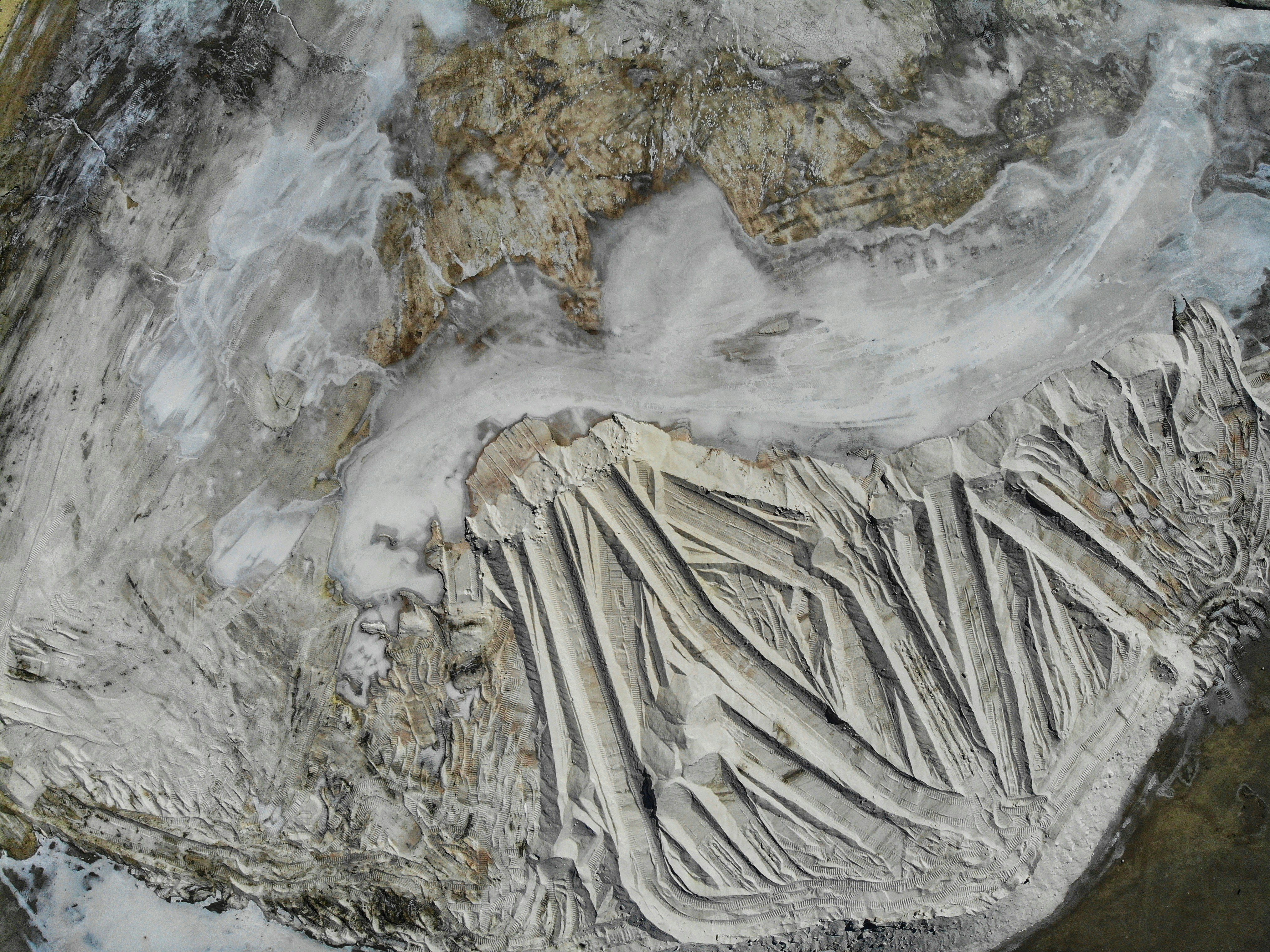 Aerial view of intricate rock formations with distinct linear patterns and varied textures.