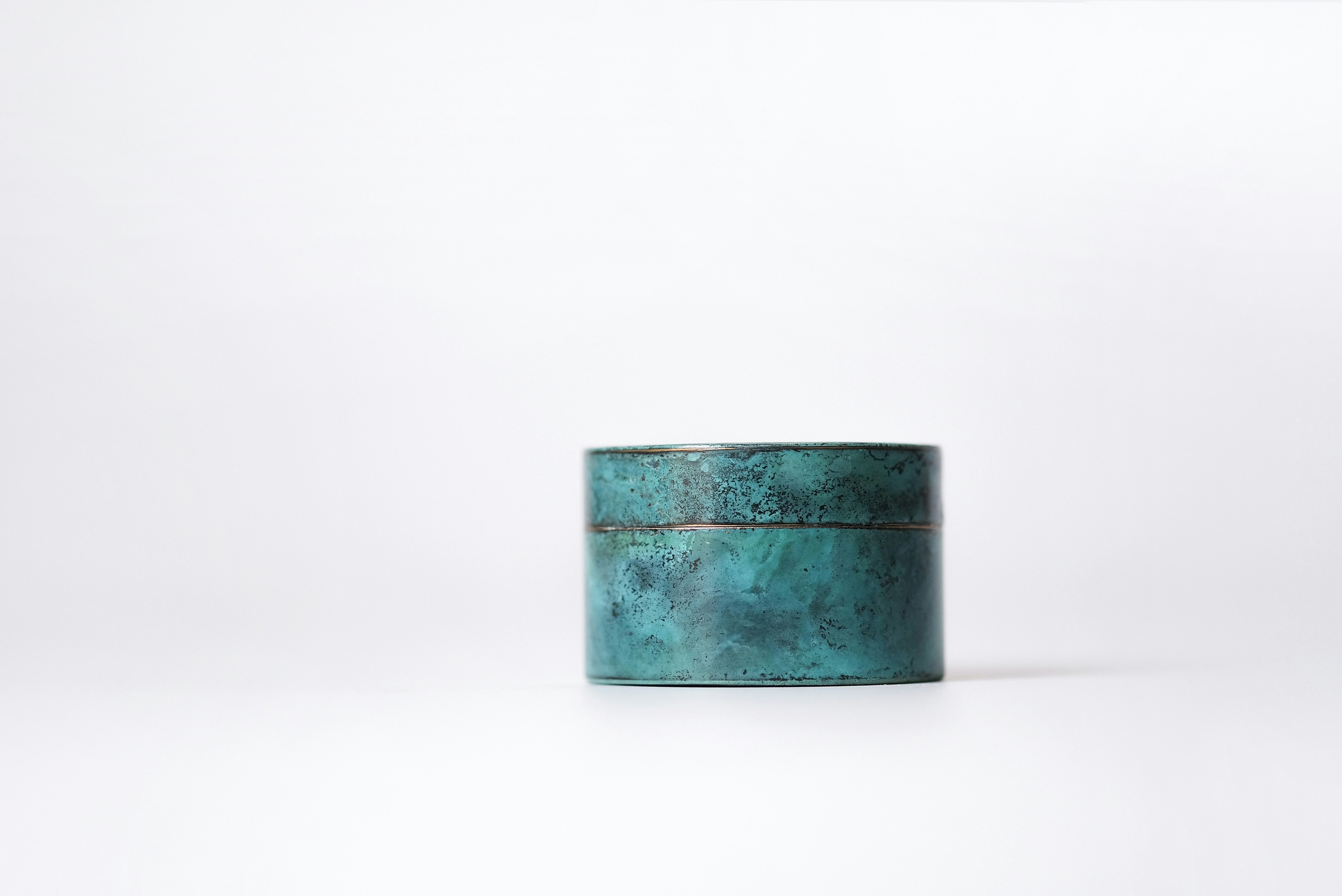 A green metal container sitting on top of a white surface photo – Free ...