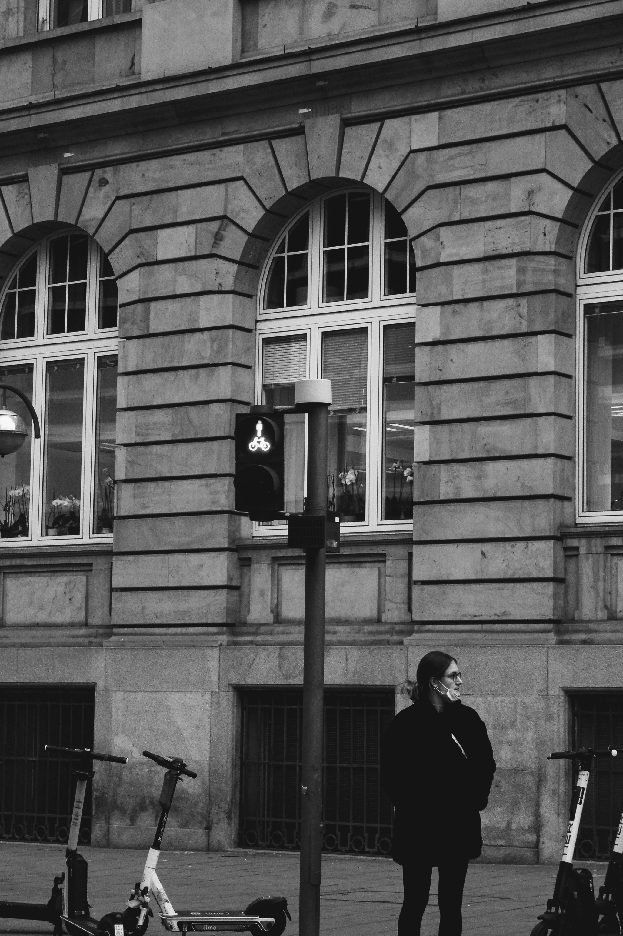 Solitary Figure Framed by Arches and Streetlamp