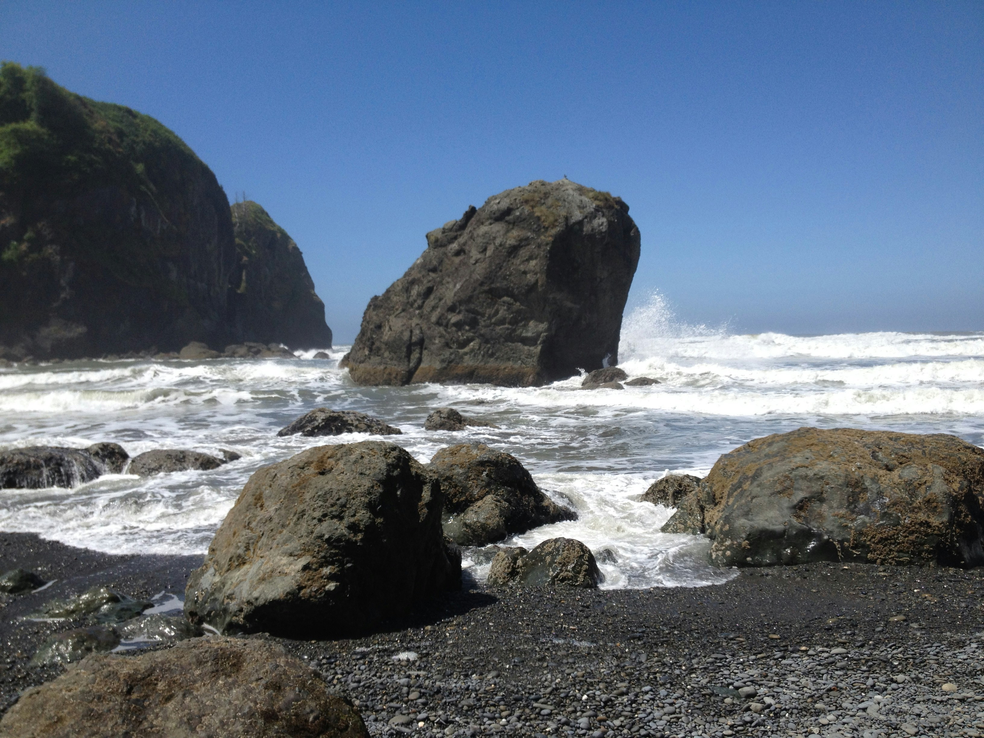 Un gros rocher assis au sommet d’une plage au bord de l’océan photo ...