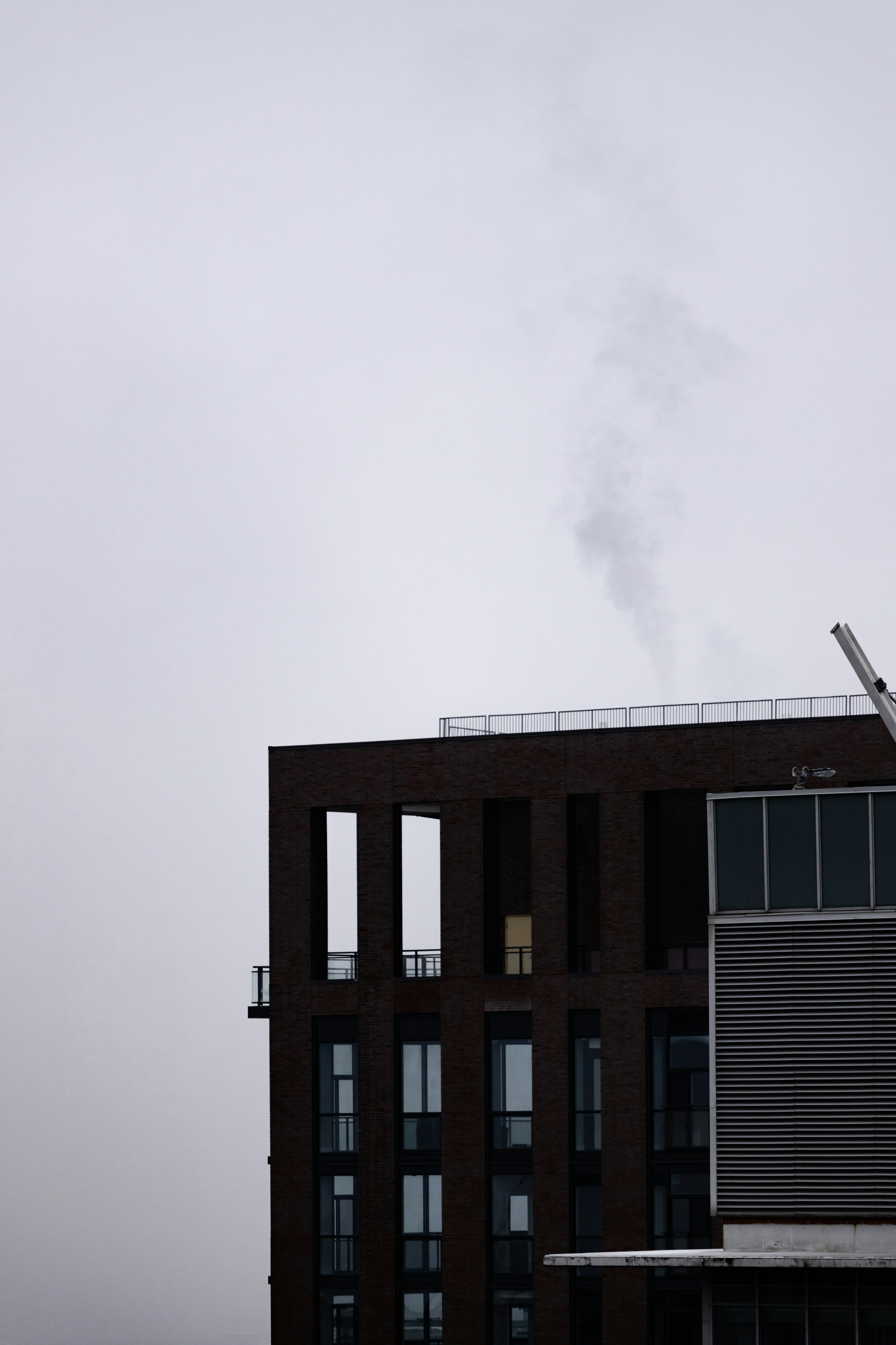 Industrial Skyline: Brick Facade and Steam in Overcast Light