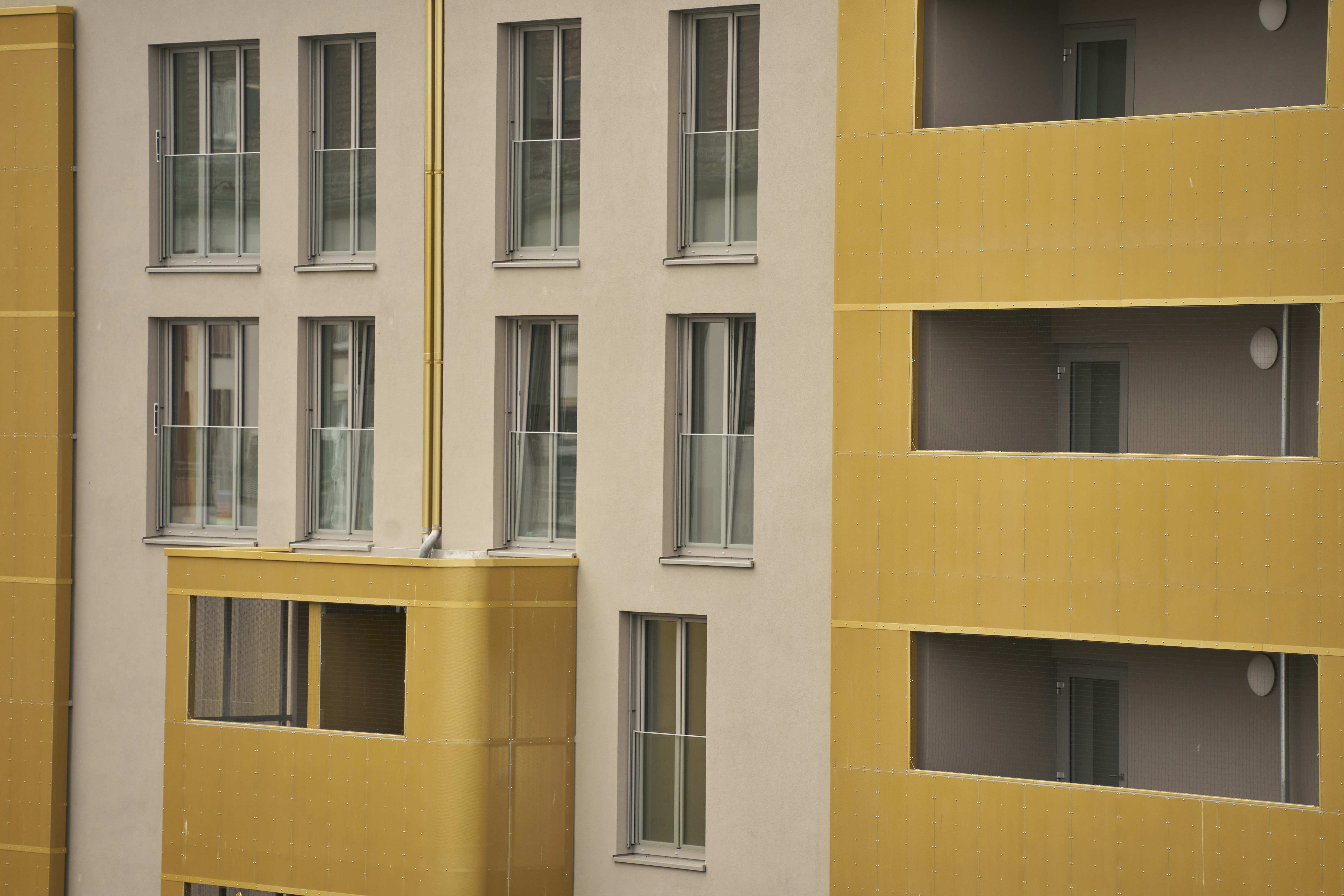 Un bâtiment jaune et blanc avec des fenêtres et des balcons photo ...